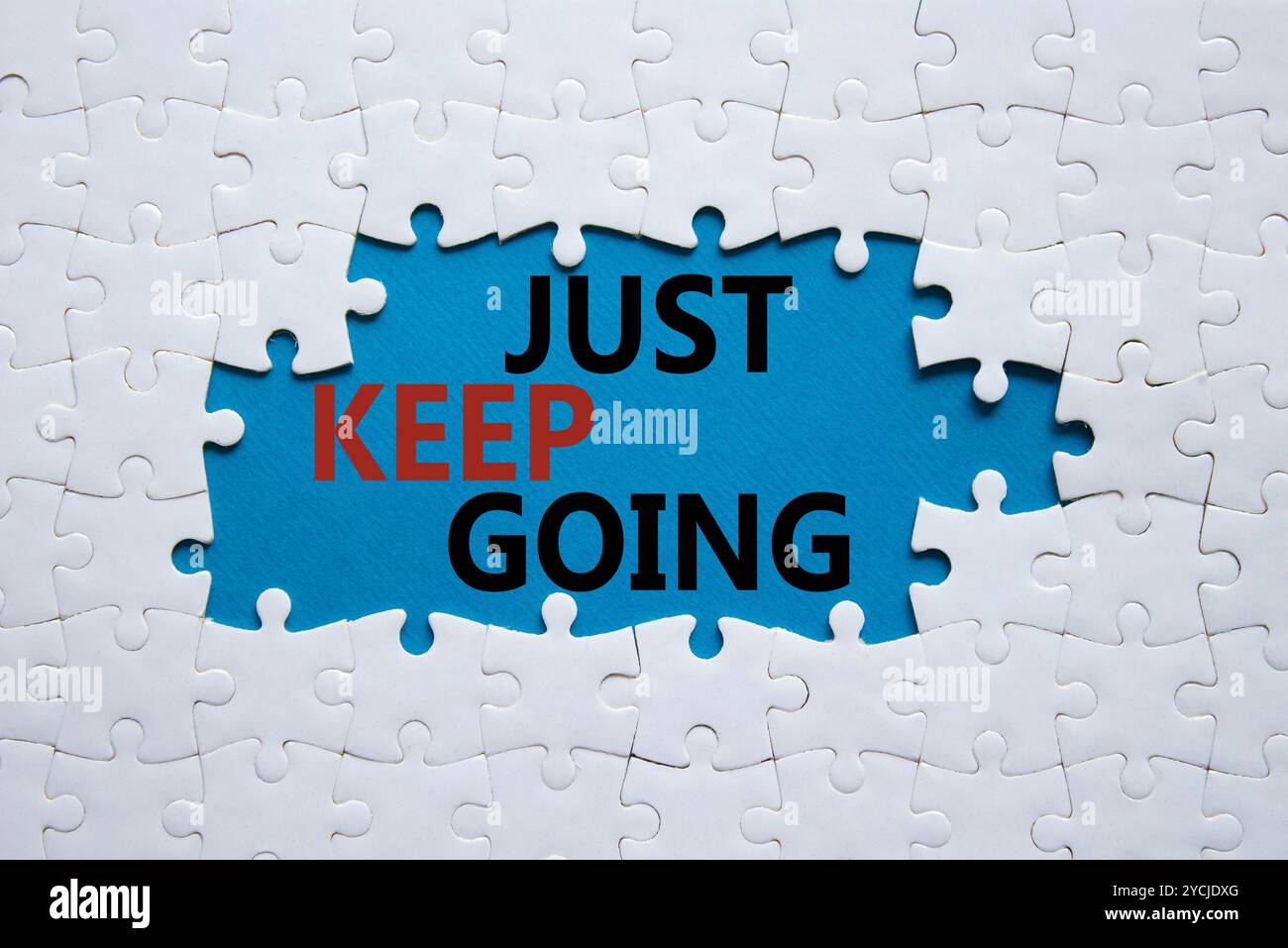 Just keep going symbol. White puzzle with words Just keep going. Beautiful blue background ...