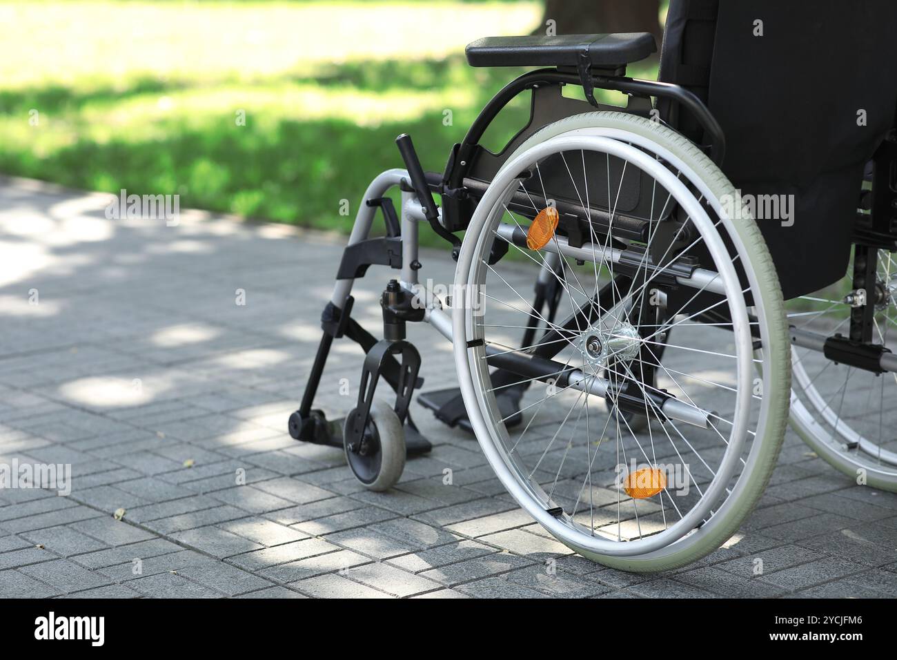 Wheelchair on paved road outdoors, closeup Stock Photo - Alamy