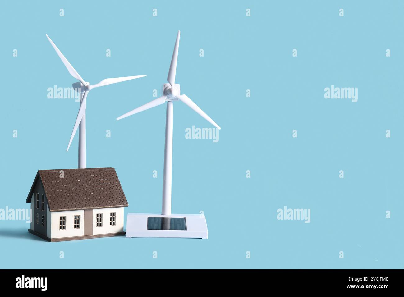 Wind turbine and house models on blue background Stock Photo - Alamy