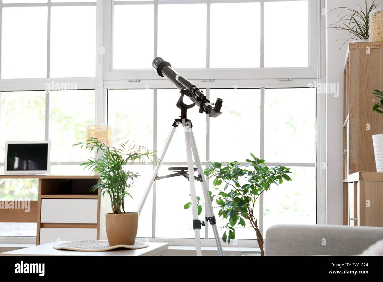 Interior of living room with modern telescope near window Stock Photo ...
