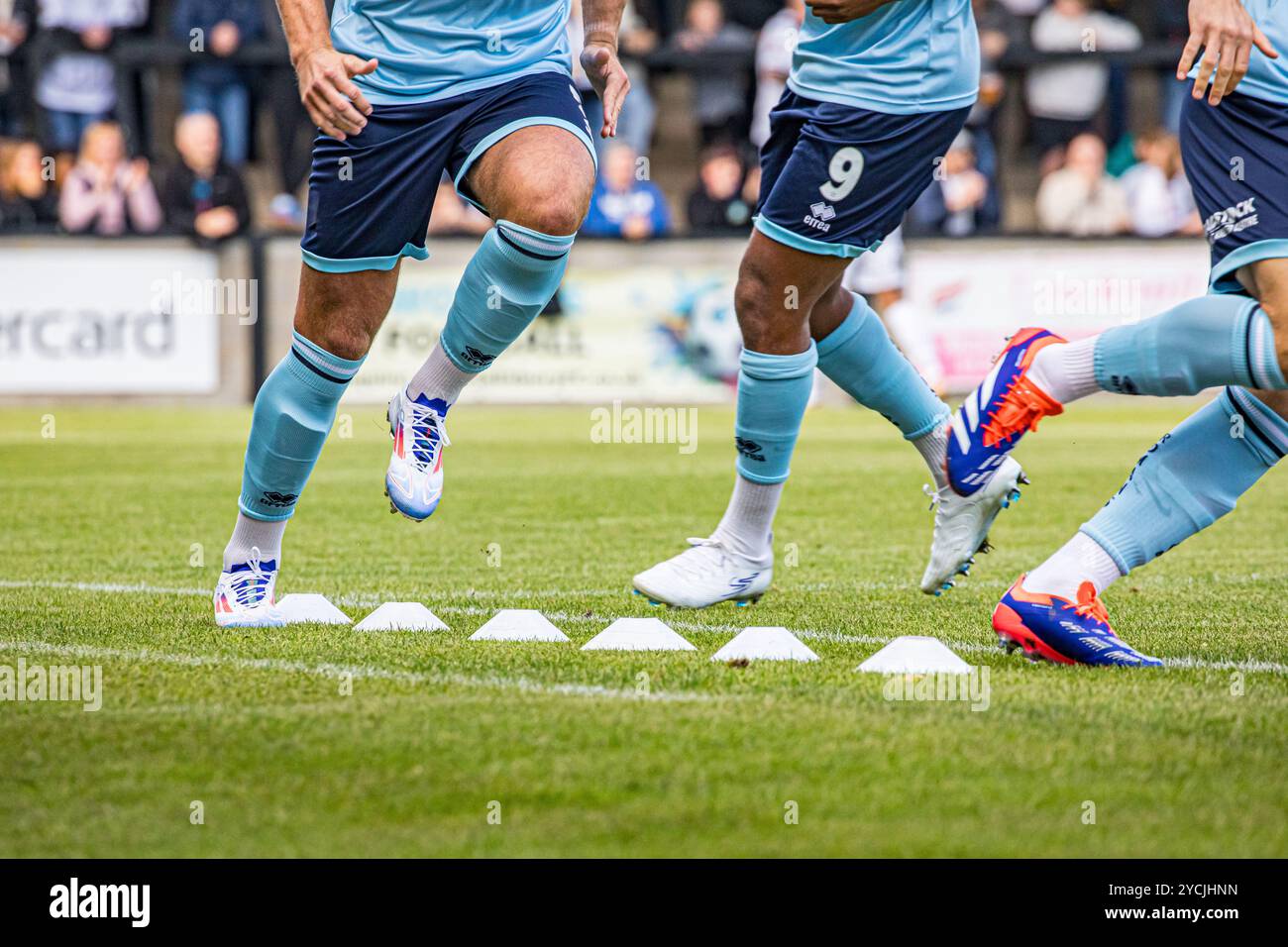 Football players legs and feet in light and dark blue football kit ...