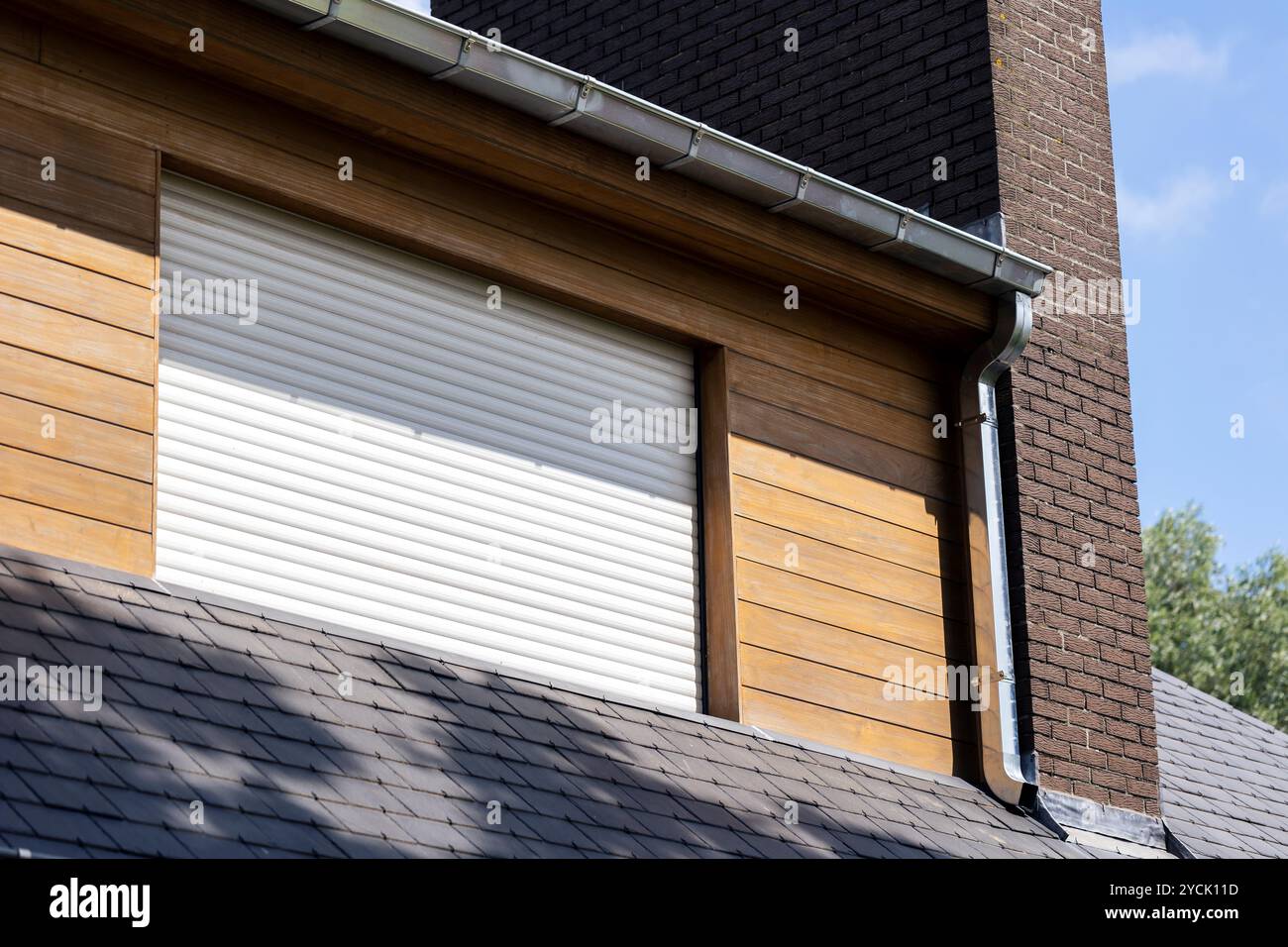 A close-up of a house exterior showing a white roller shutter window ...