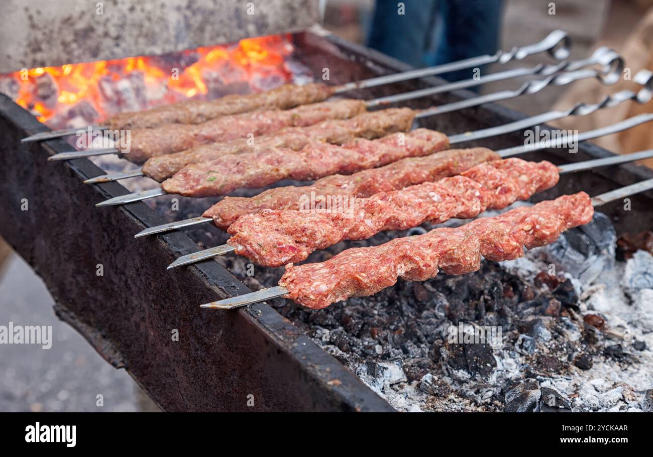 Preparation of meat slices in sauce on fire Stock Photo - Alamy