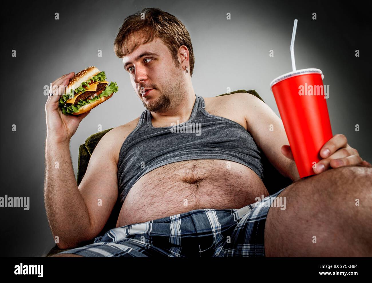 Fat man eating hamburger Stock Photo - Alamy