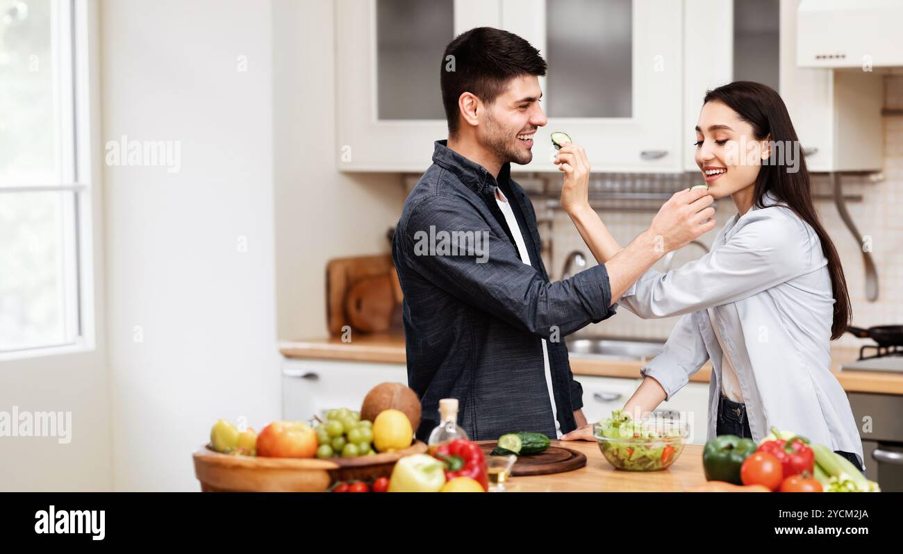 Lovely couple preparing dinner and feeding each other Stock Photo - Alamy
