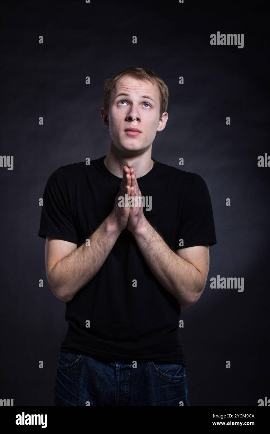 Prayer man on black background Stock Photo - Alamy