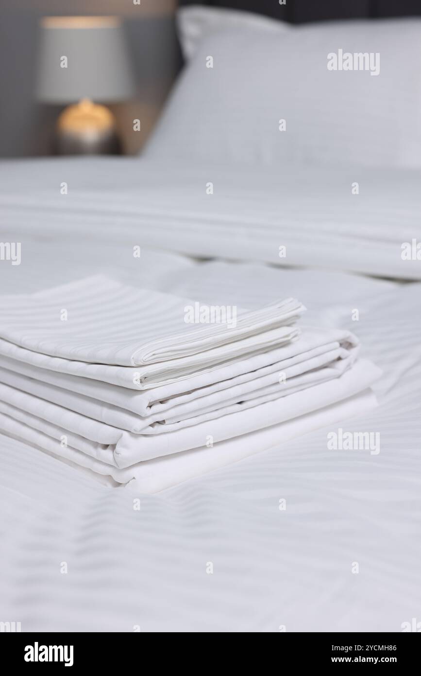 Stack of clean linens on bed indoors Stock Photo - Alamy