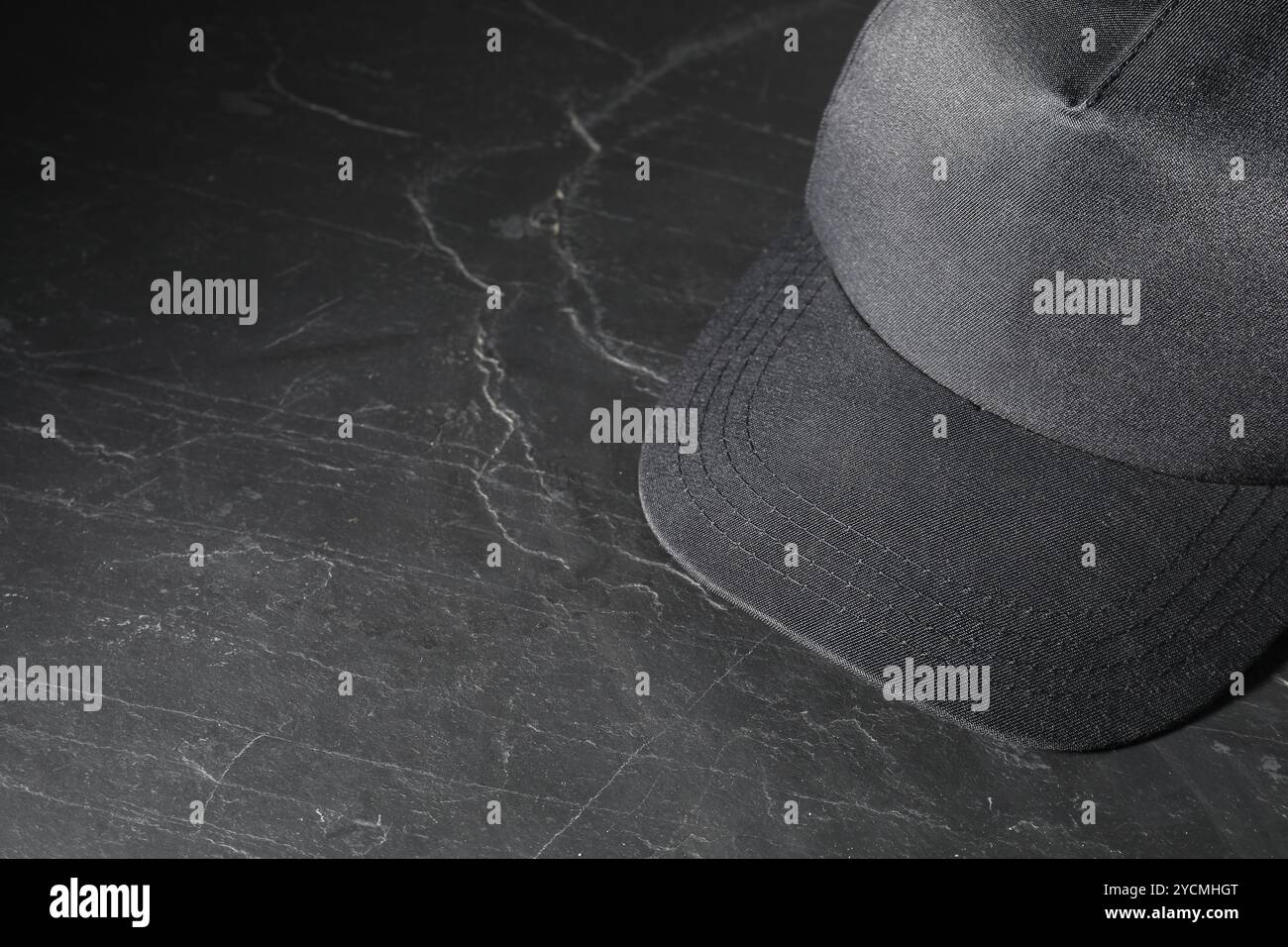 Stylish baseball cap on dark textured table, closeup. Mockup for design ...