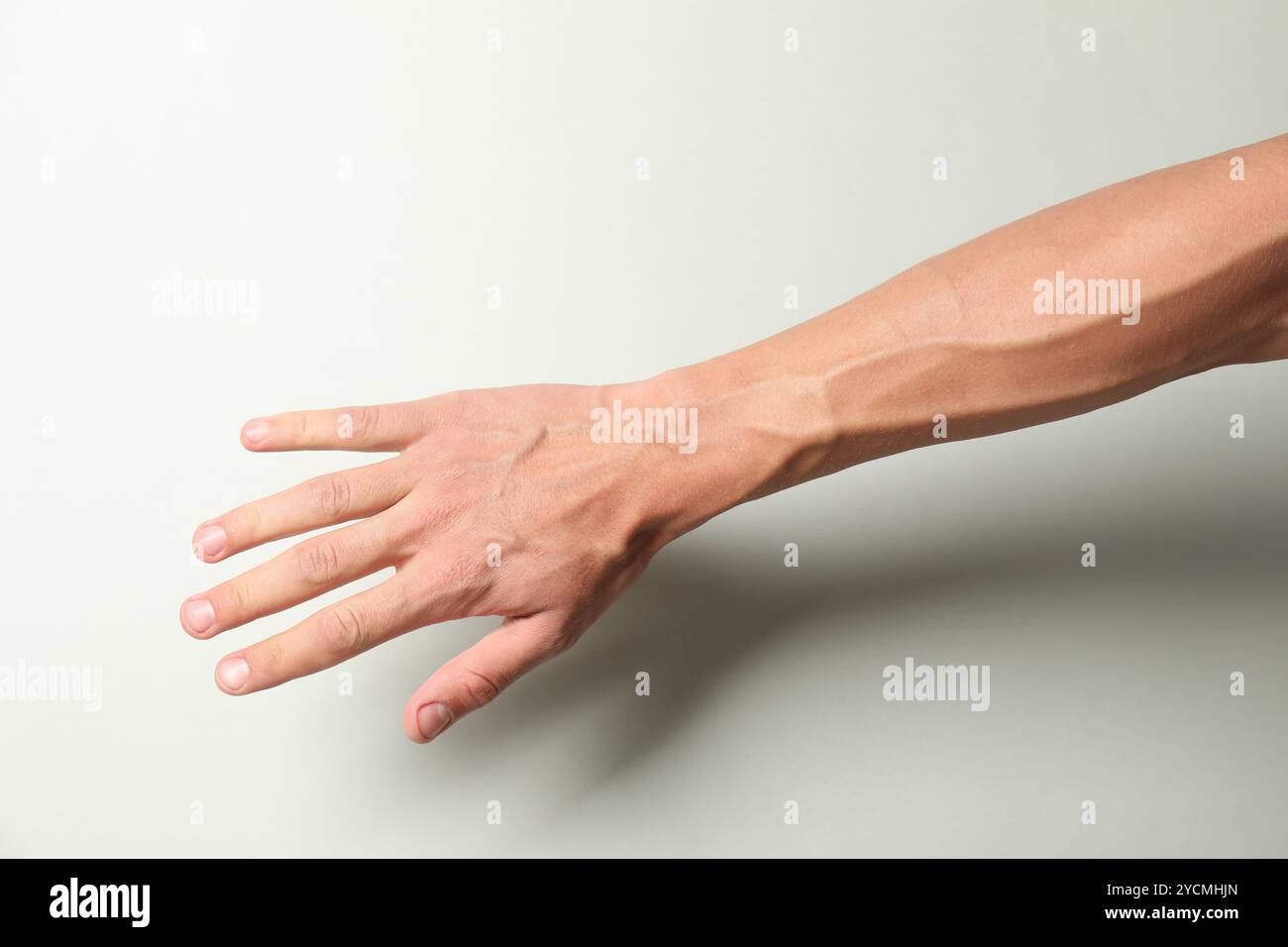 Man with bulging veins on his arm against light background, closeup ...