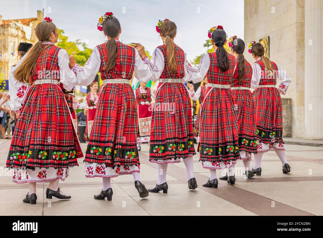 A group of dancers in colorful traditional costumes performing folk ...