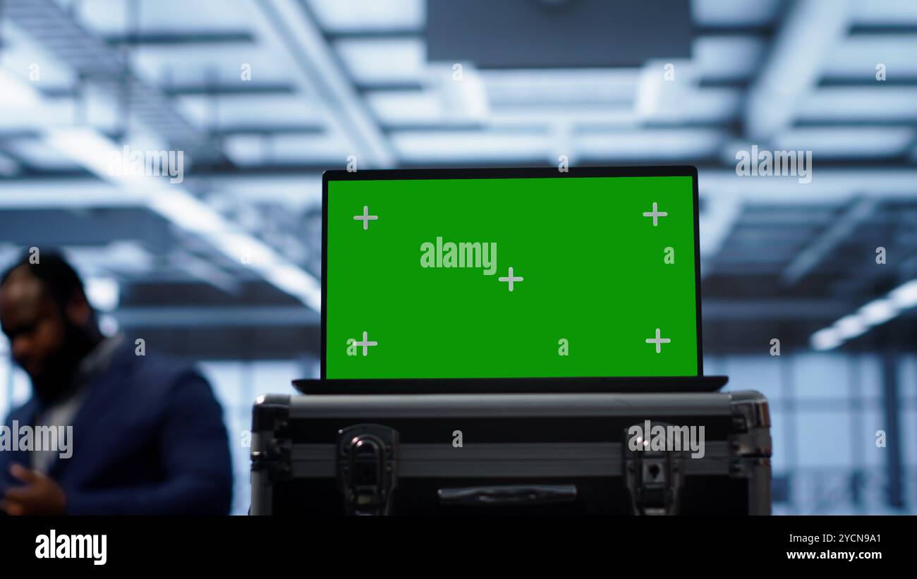 Green screen laptop used by engineers monitoring server room, doing ...