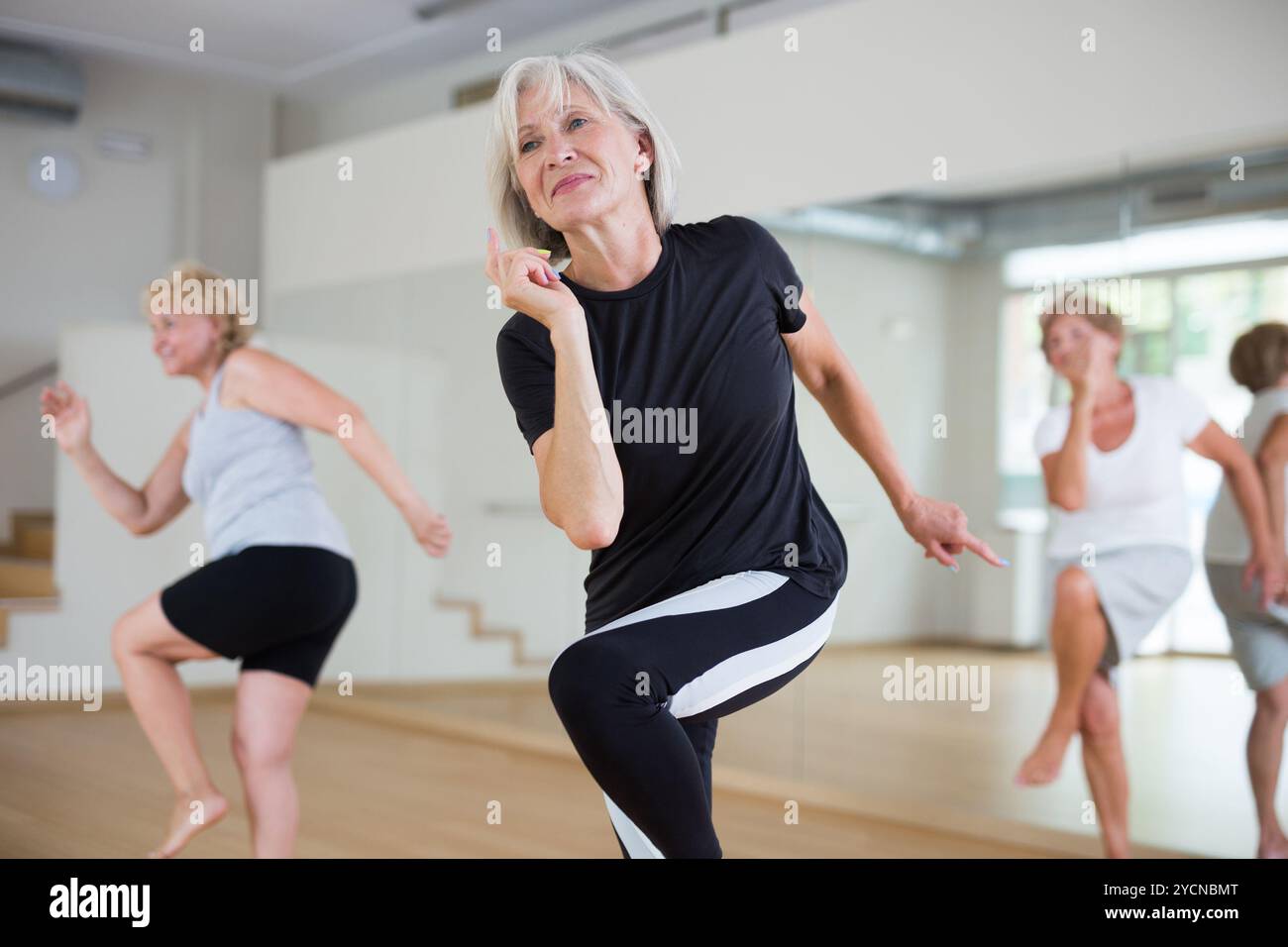 Positive aged woman practicing vigorous dance movements Stock Photo - Alamy