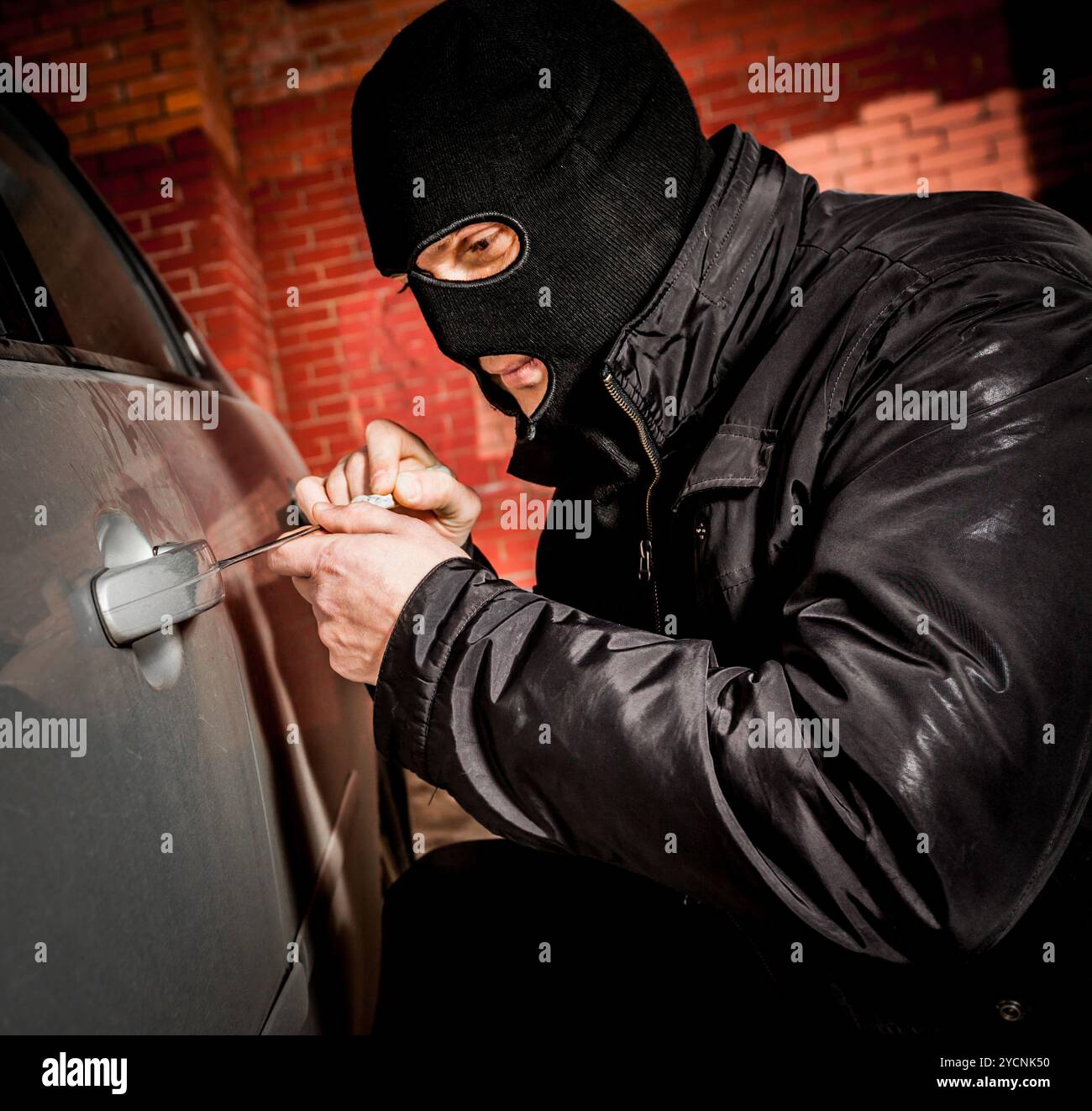Car thief in a mask Stock Photo - Alamy