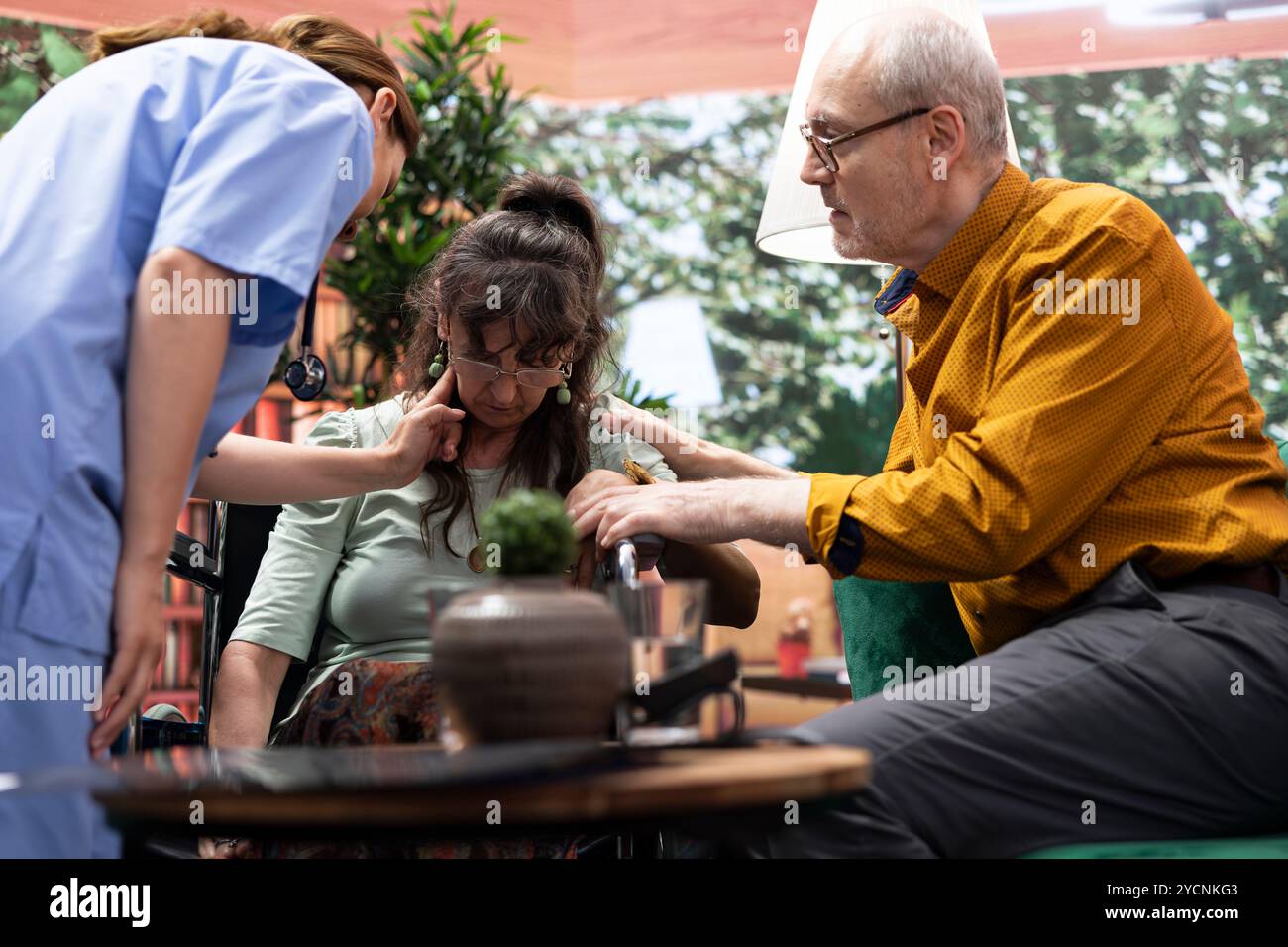 Sick elderly woman with disability fainting next to nurse during ...