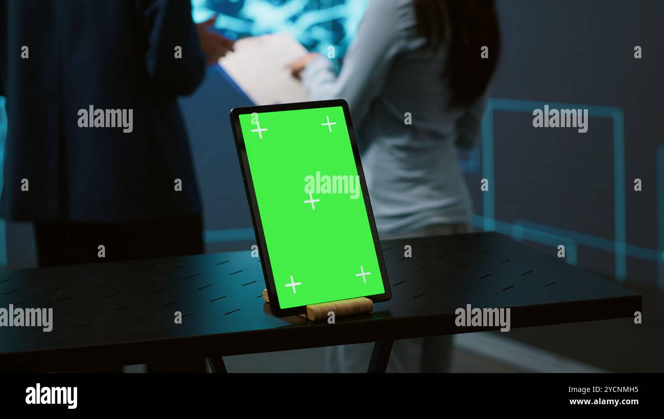 Green screen tablet used by computer scientists in startup doing advancements in AI field ...