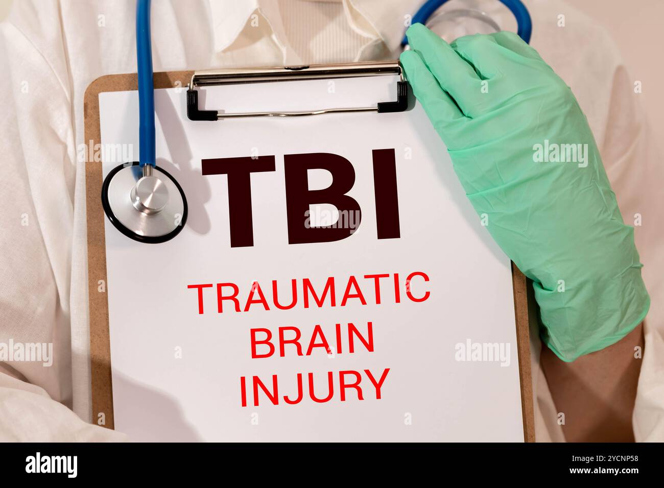TBI traumatic brain injury symbol. Concept words TBI traumatic brain injury on white note on a ...