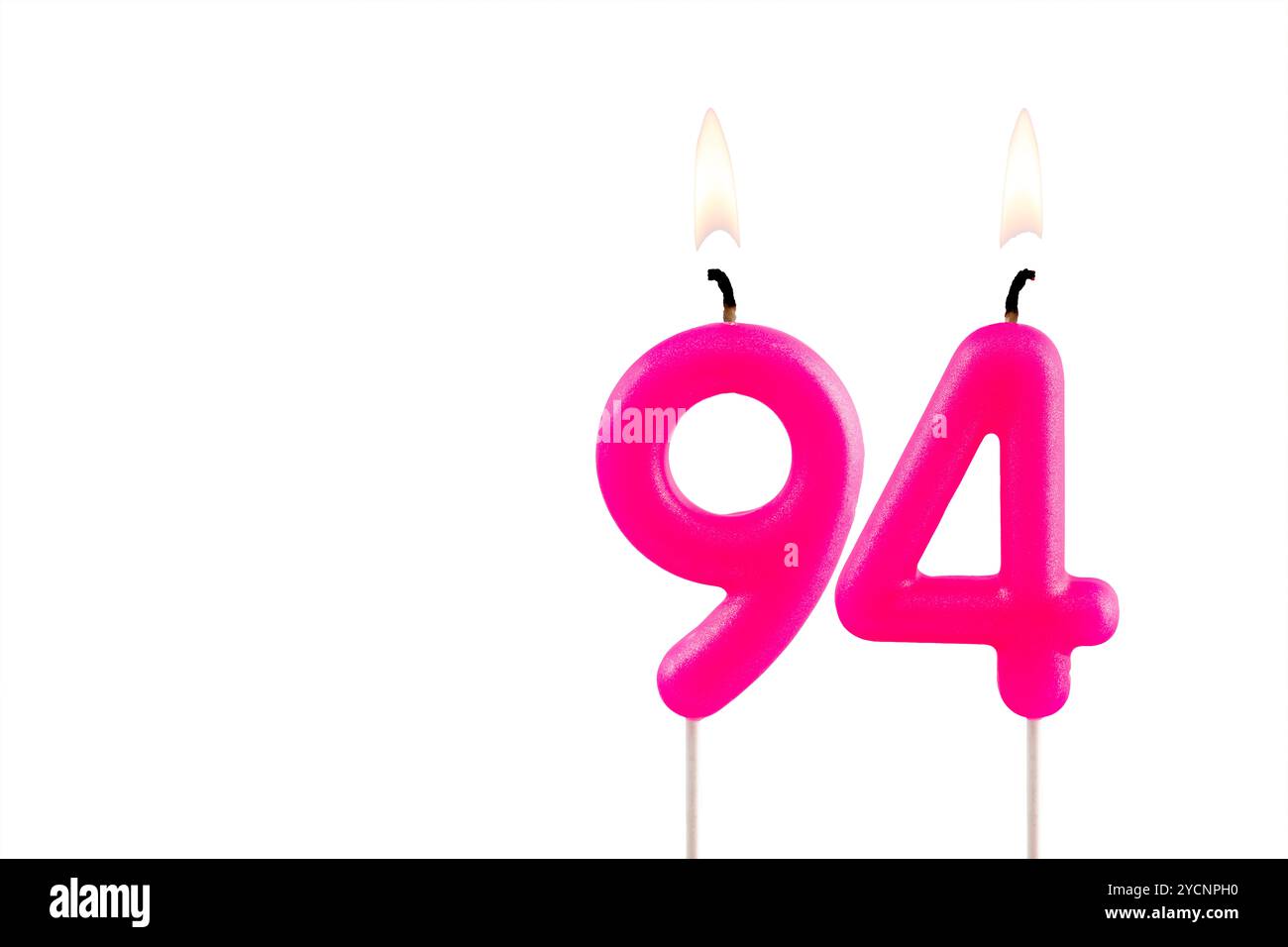 Pink number 94 birthday candle lit on white background Stock Photo - Alamy