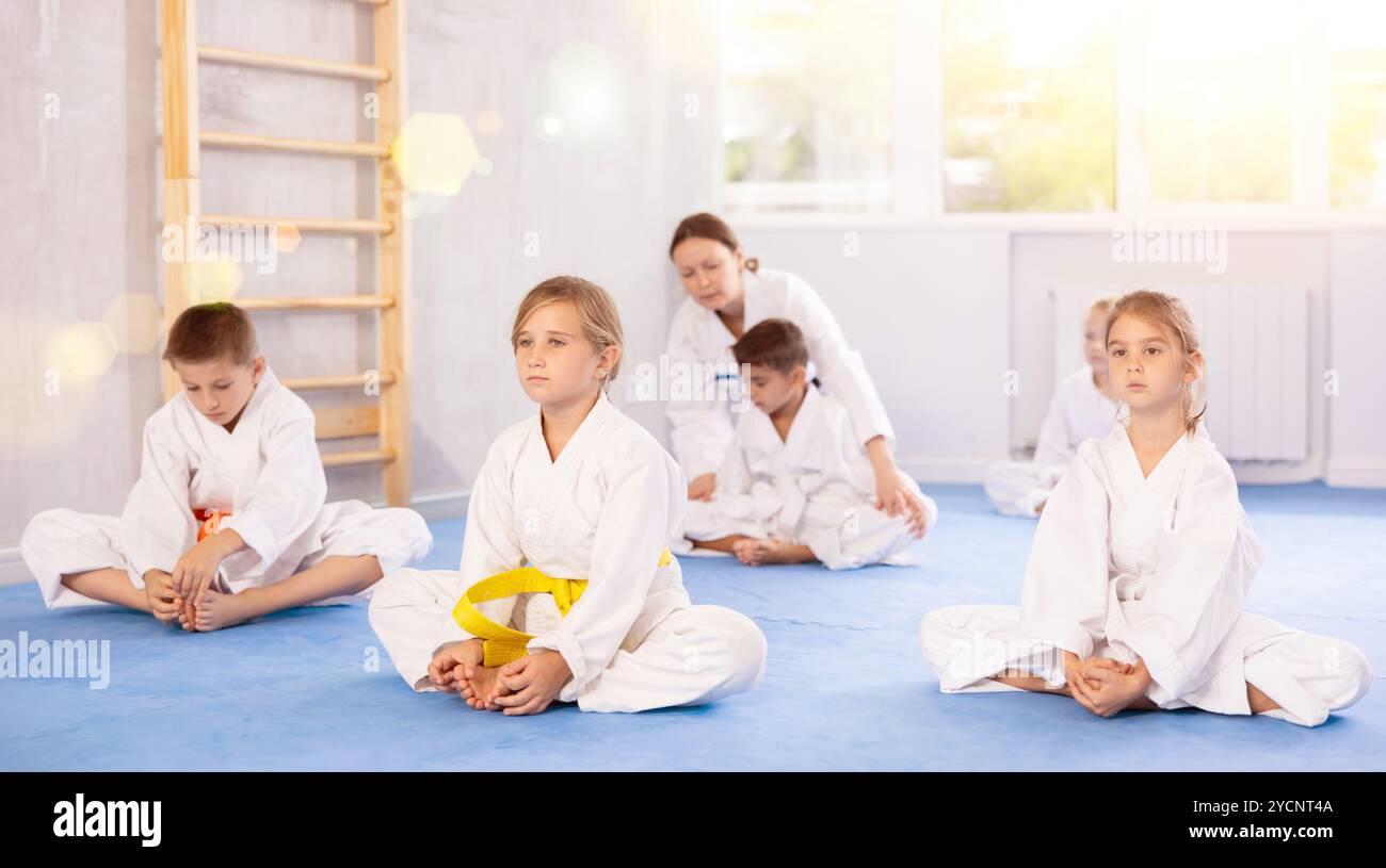 Children before training martial arts performs stretching butterfly ...
