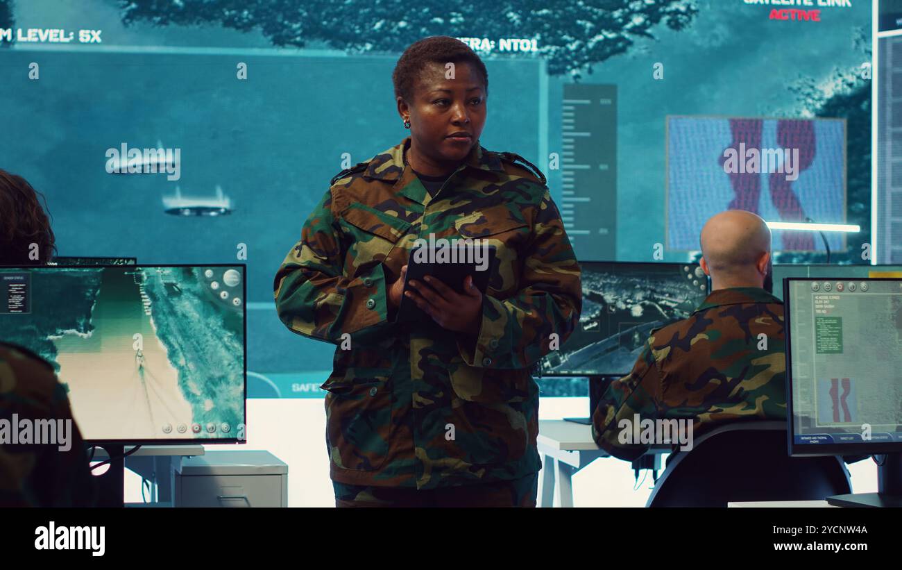 Female military officer supervising radar surveillance footage to input ...