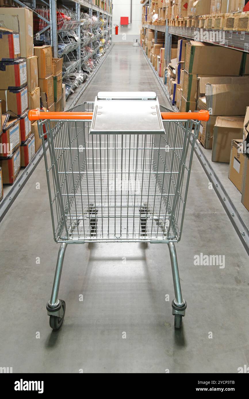 Shopping trolley in warehouse row with boxes Stock Photo - Alamy