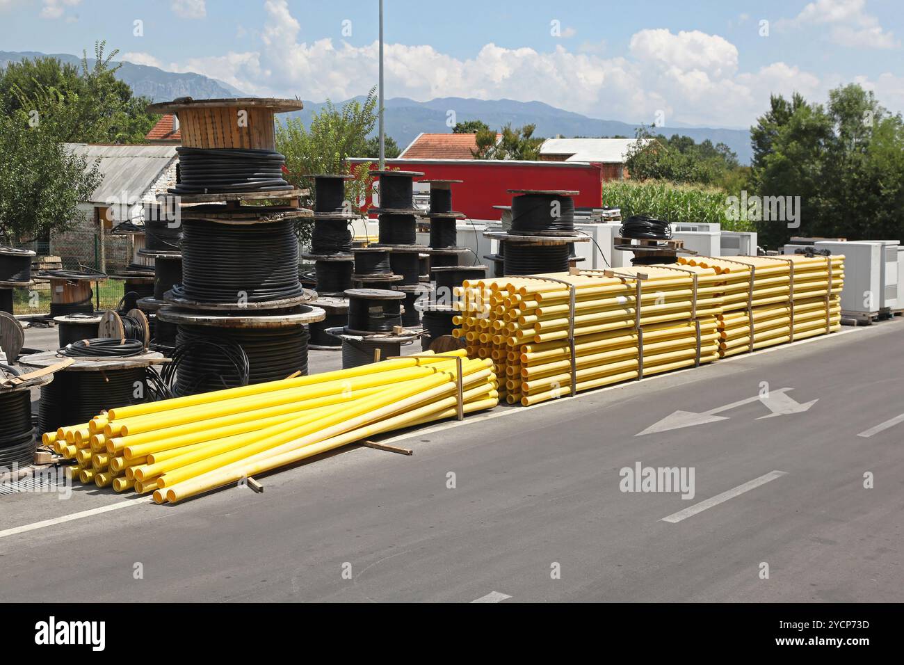 Construction pipes and cable reels at open storage Stock Photo - Alamy