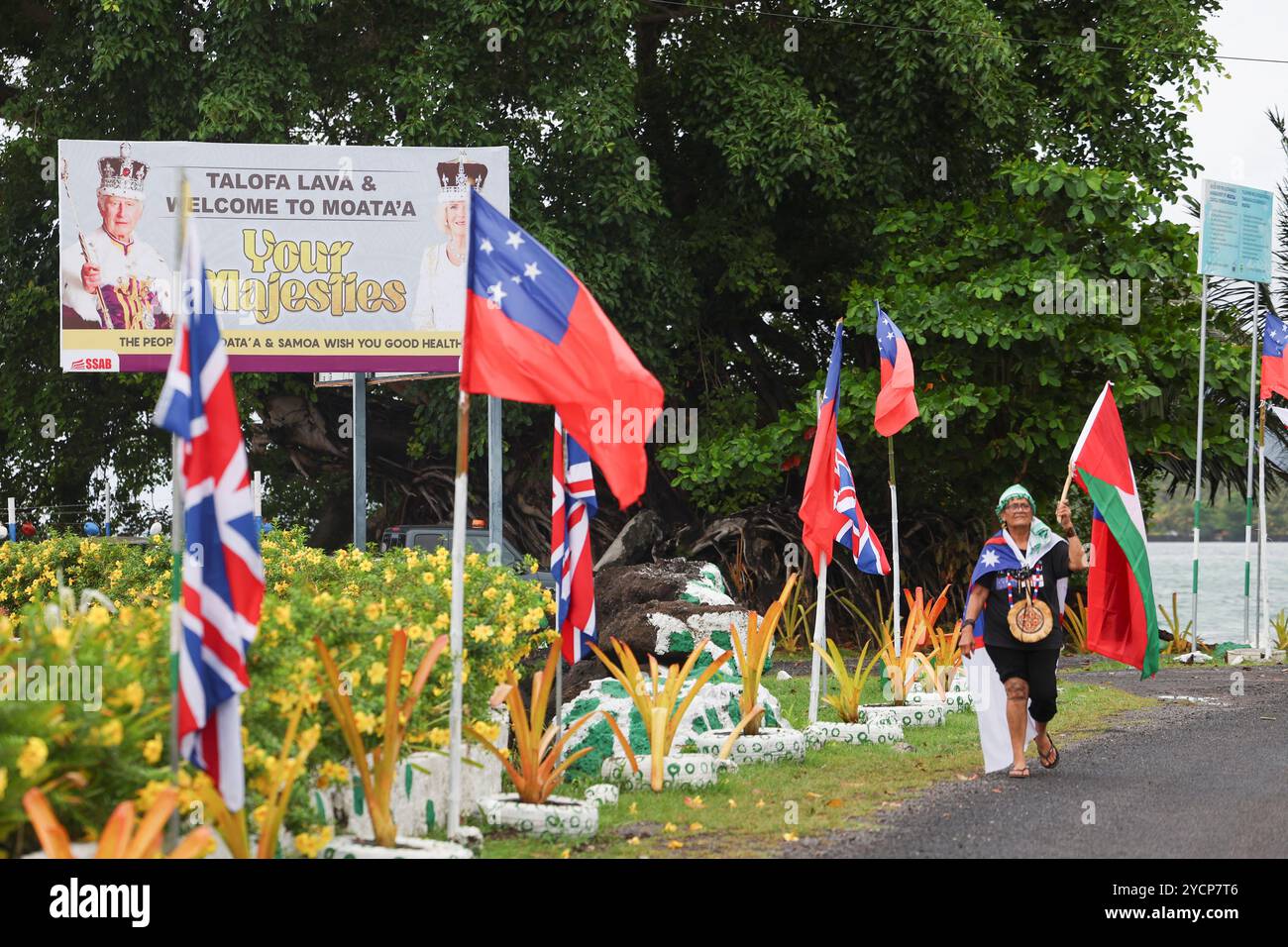 People walk past a welcome sign ahead of the arrival of King Charles ...