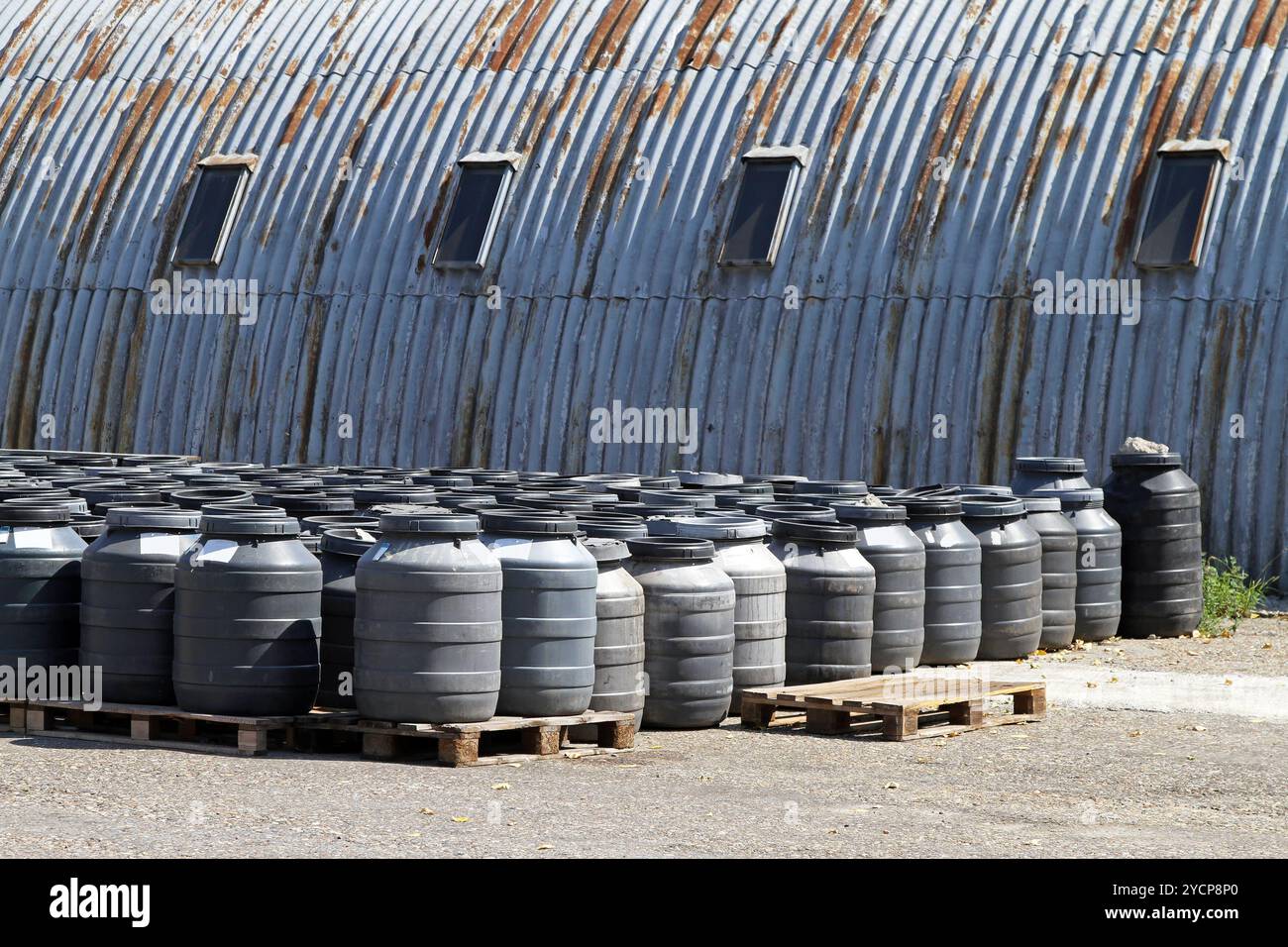 Industrial waiste in plastic barrels near warehouse Stock Photo - Alamy