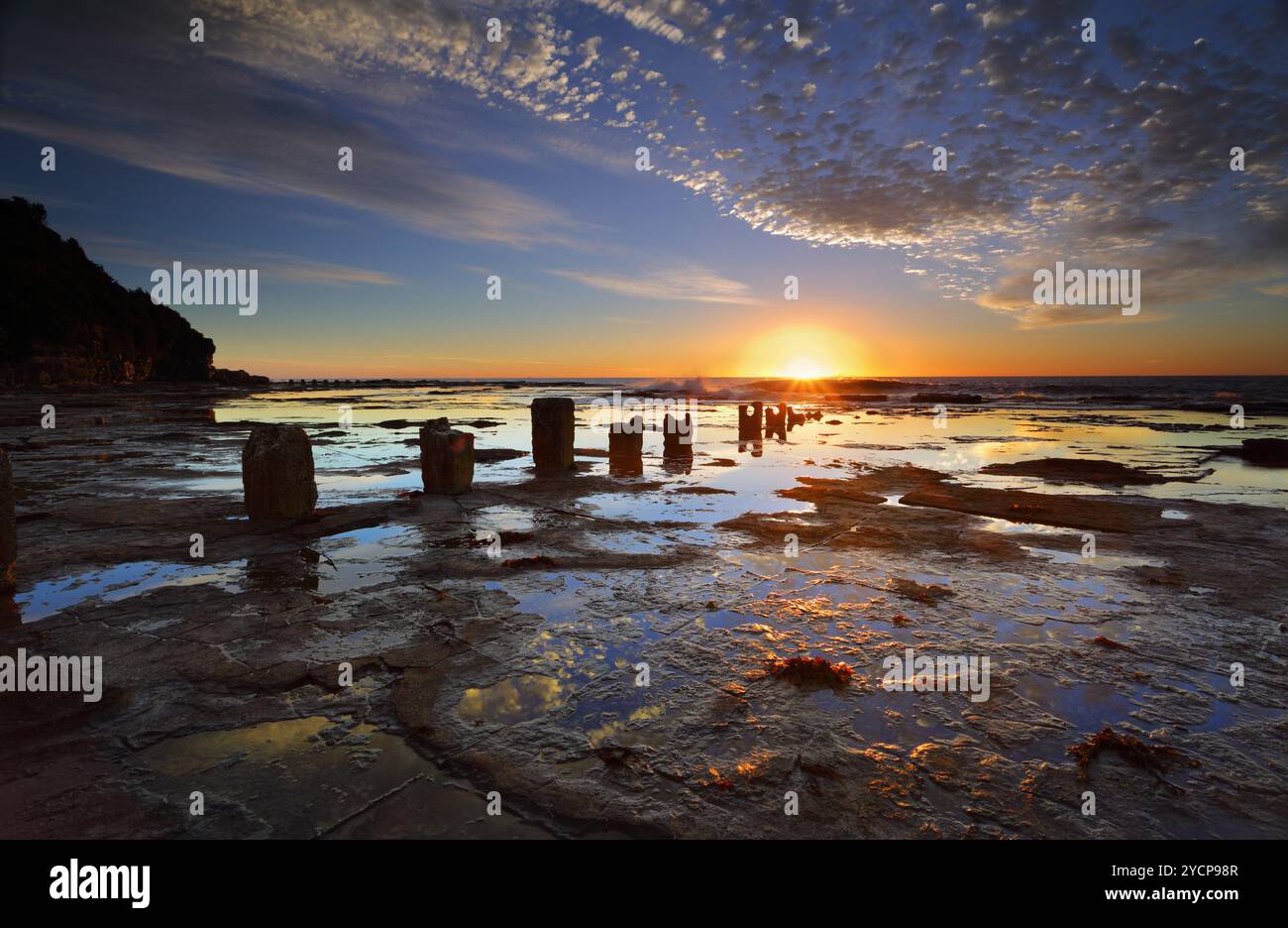 The golden sun rises on the horizon its first rays of light streaking ...