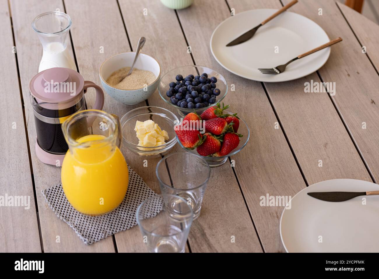 Breakfast table with fresh fruit, orange juice, and coffee ready for ...
