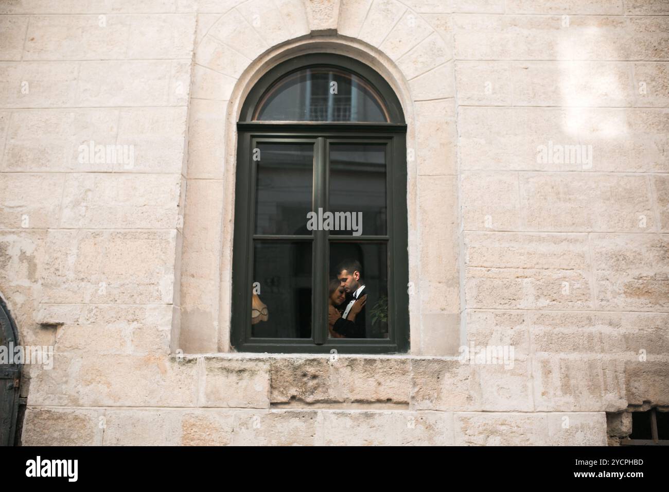 Wedding couple kissing in the window Stock Photo - Alamy