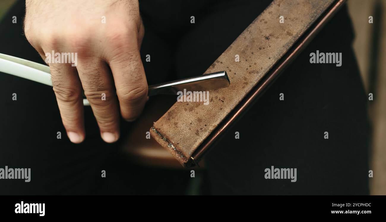 Strong man sharpens old razor Stock Photo - Alamy