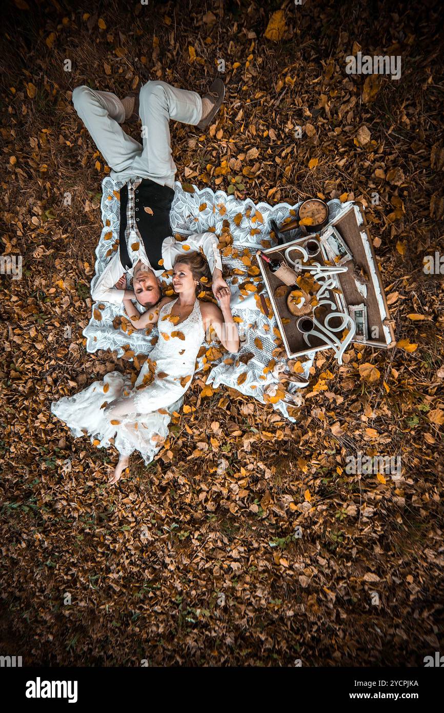 Wedding couple lying under a tree Stock Photo - Alamy
