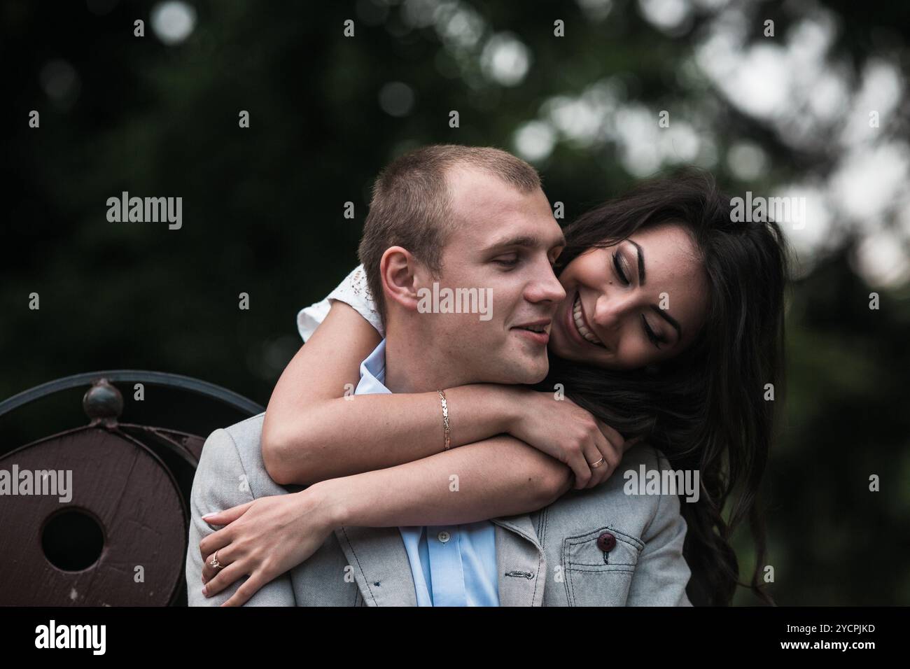 Young European couple cuddling on a park bench Stock Photo - Alamy