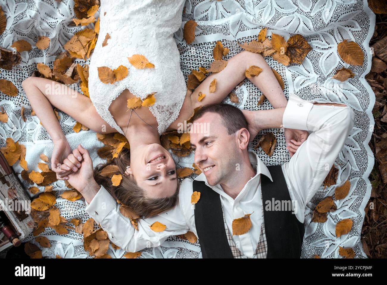 Wedding couple lying under a tree Stock Photo - Alamy