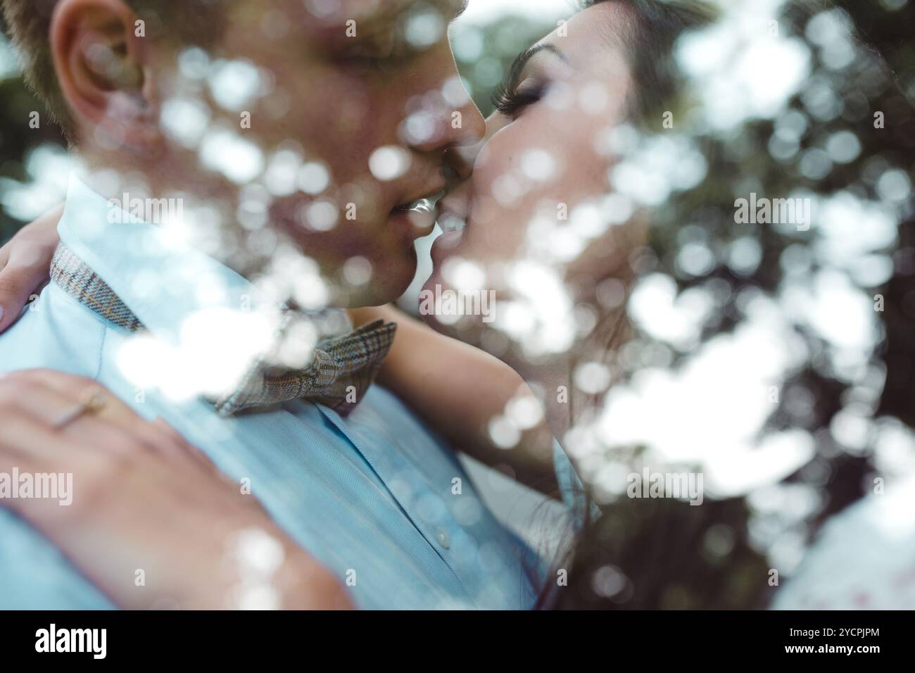 Young European couple cuddling on a park bench Stock Photo - Alamy