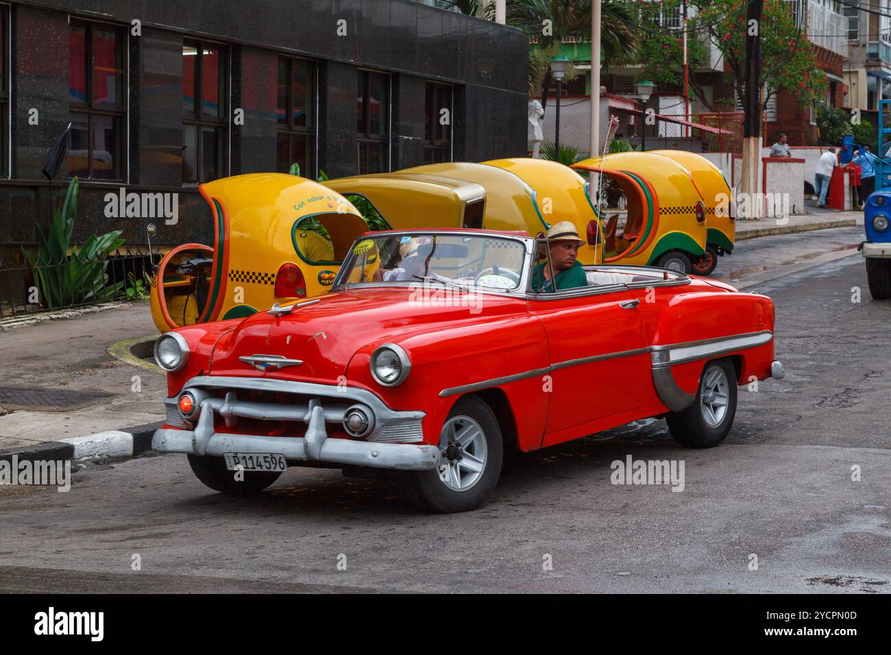 A Man with an havana hat on a typical red convertible vintage 50s car ...