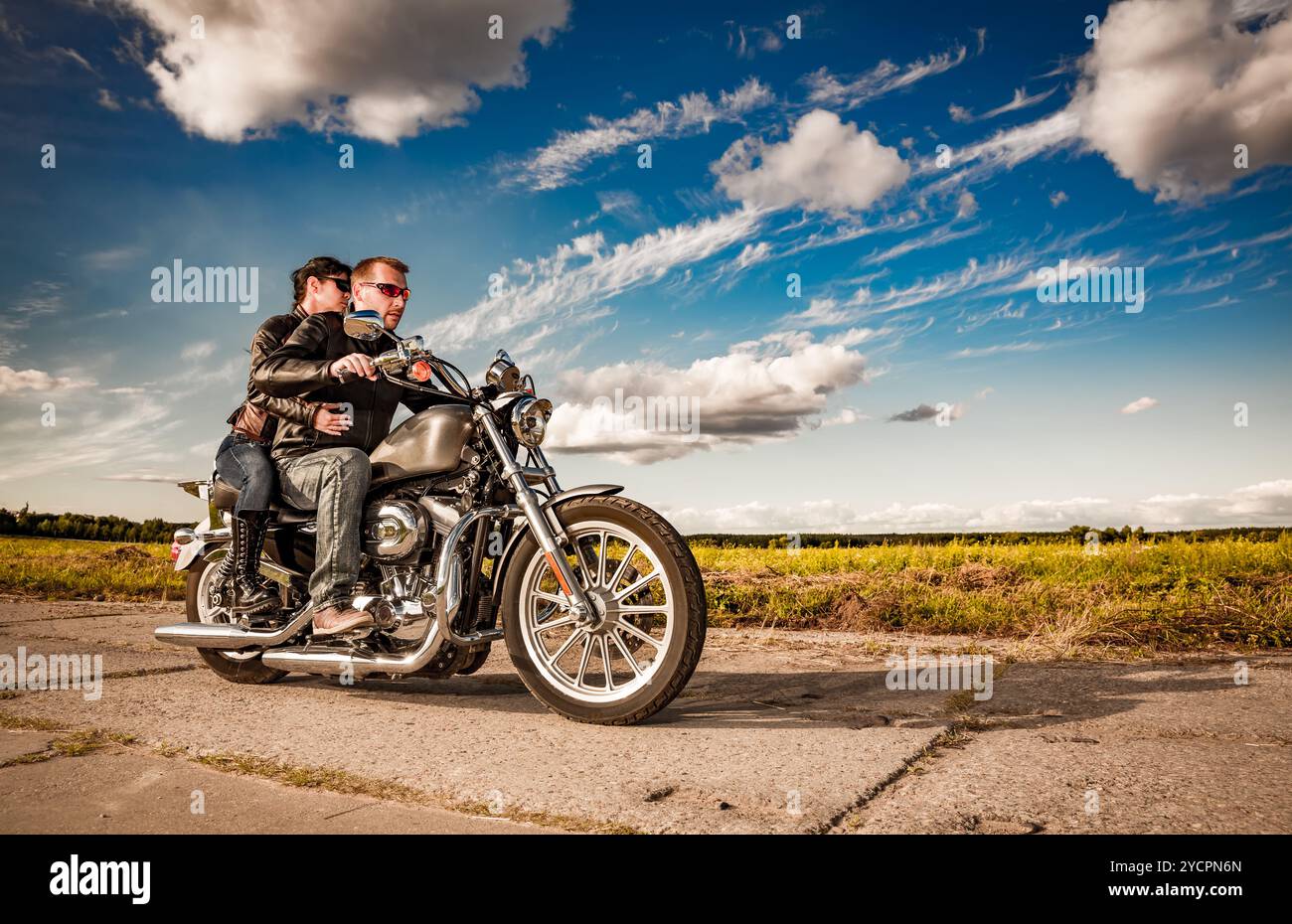 Couple Bikers in a leather jacket riding a motorcycle on the road Stock ...