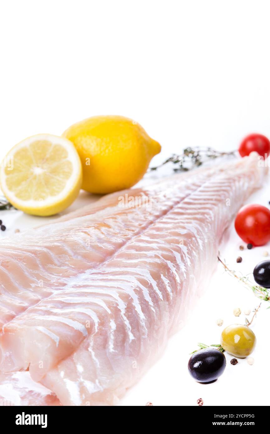 uncooked raw fillet of cod with serving spices on white background ...