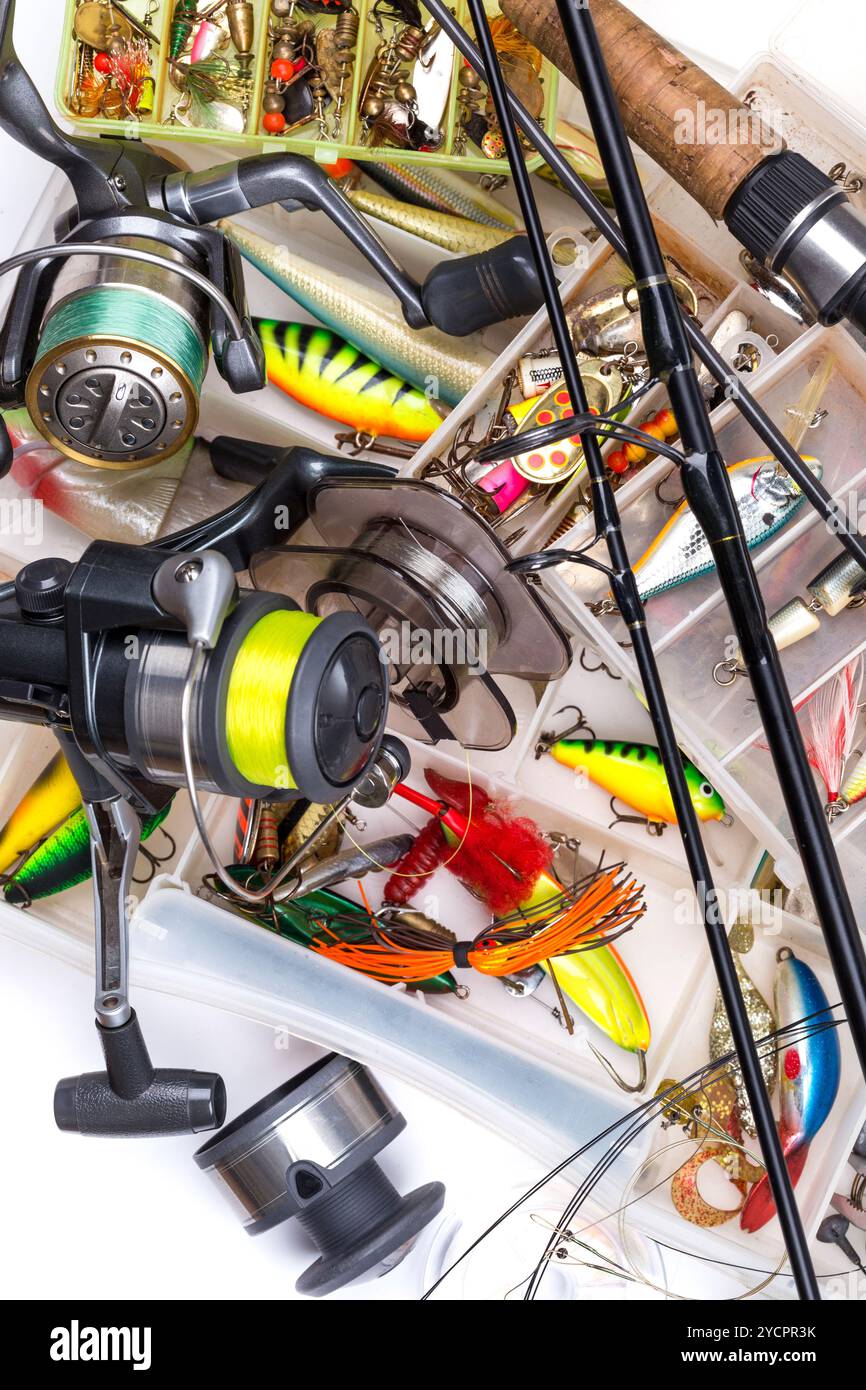 different fishing tackles - rod, reel, line and lures in box on white ...