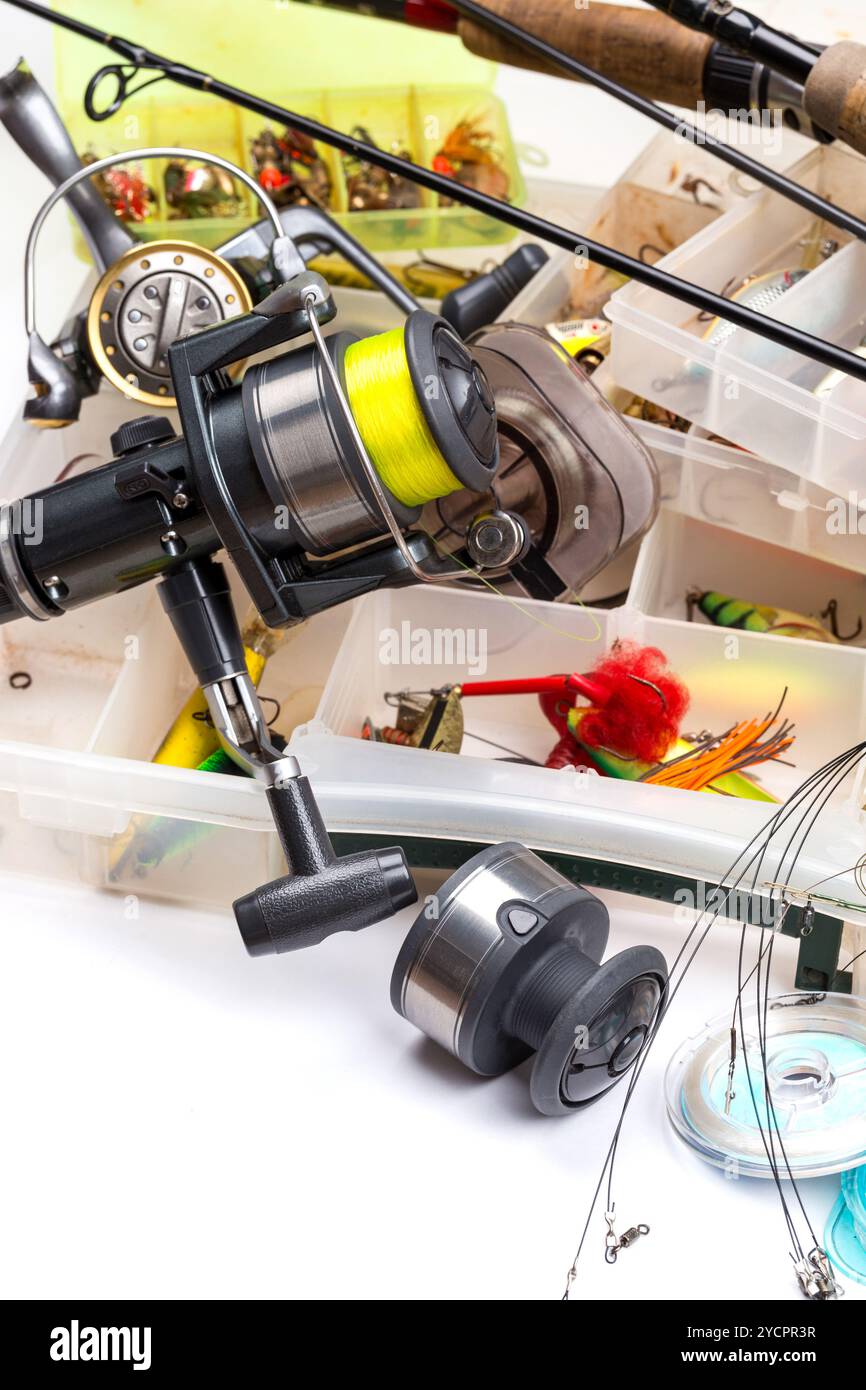 different fishing tackles - rod, reel, line and lures in box on white ...