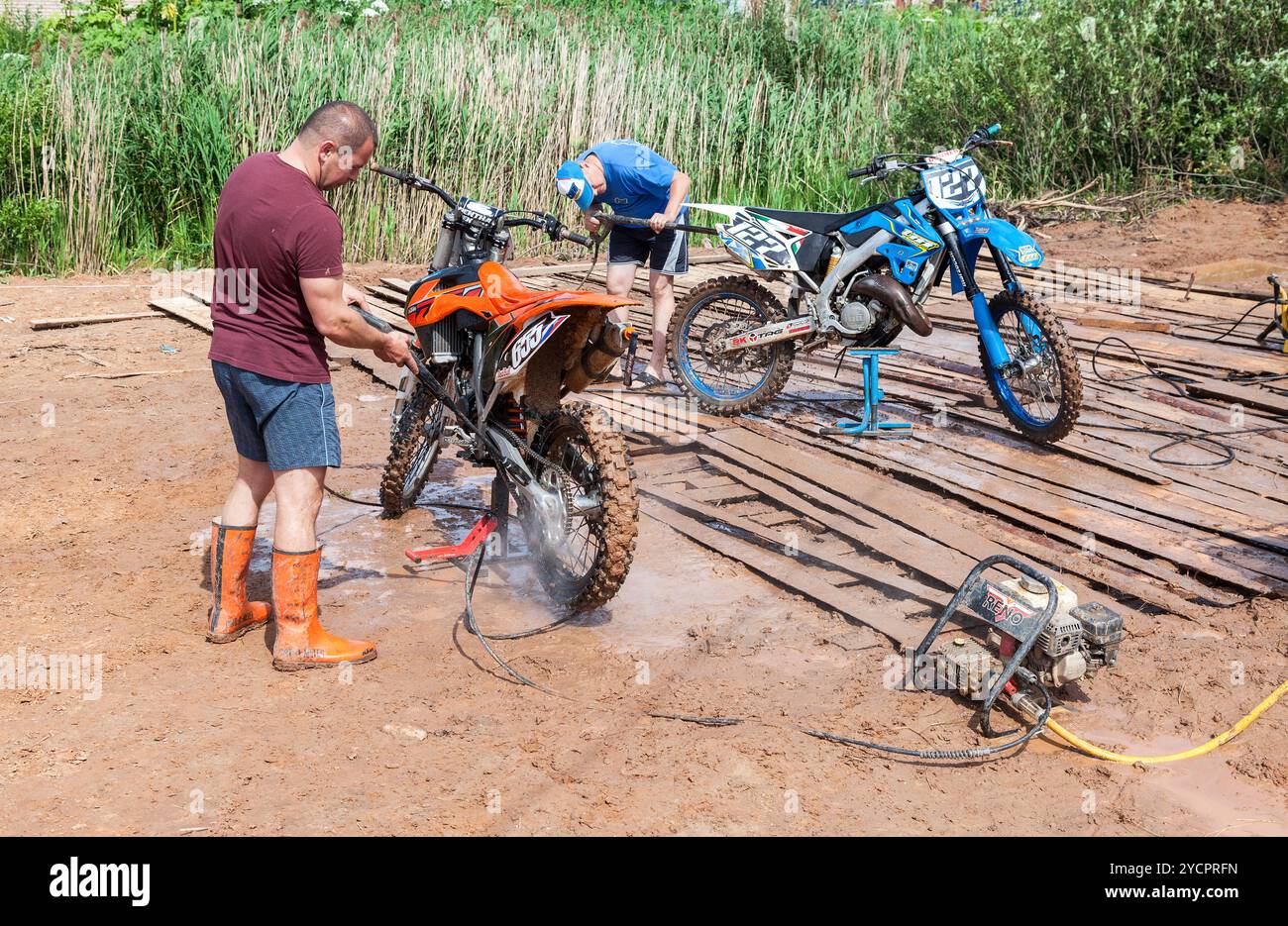Man washing a race bike after the competition in motocross Stock Photo ...
