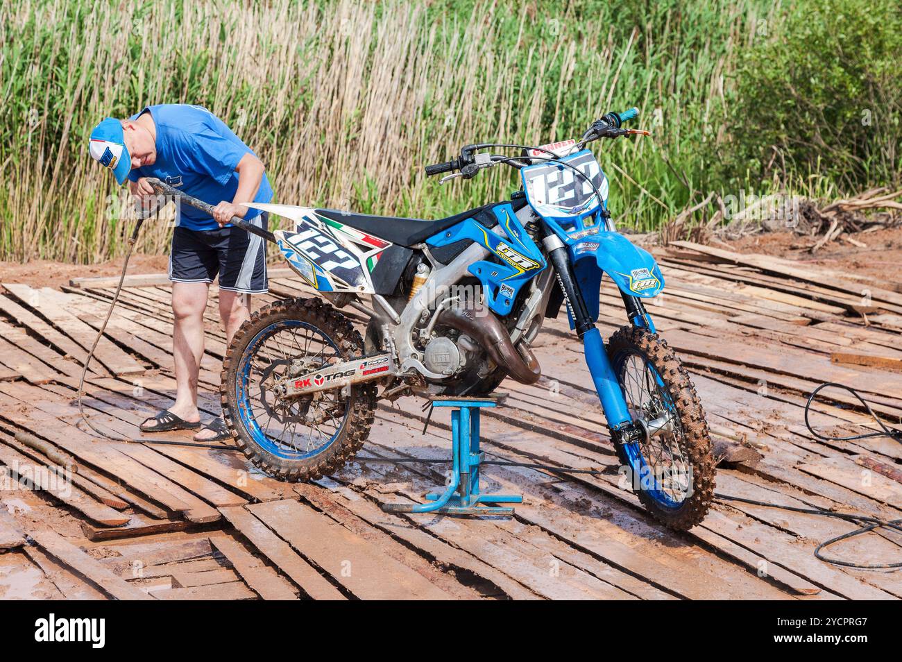 Man washing a race bike after the competition in motocross Stock Photo - Alamy