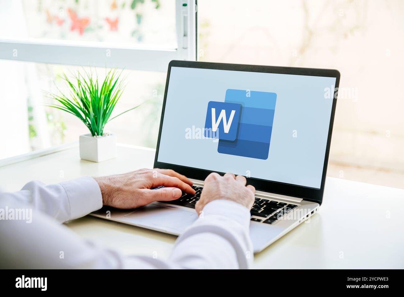 Man Using A Laptop Computer Displaying Logo Of Microsoft Word On The Screen A Text Processor