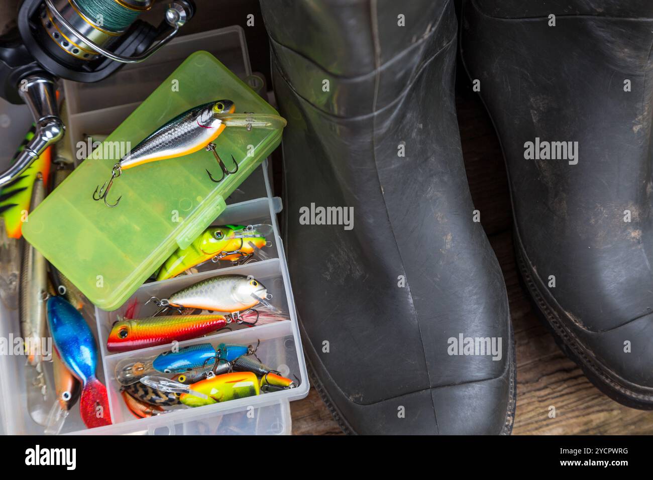 Fishing tackles and rubber boots on timber board Stock Photo - Alamy