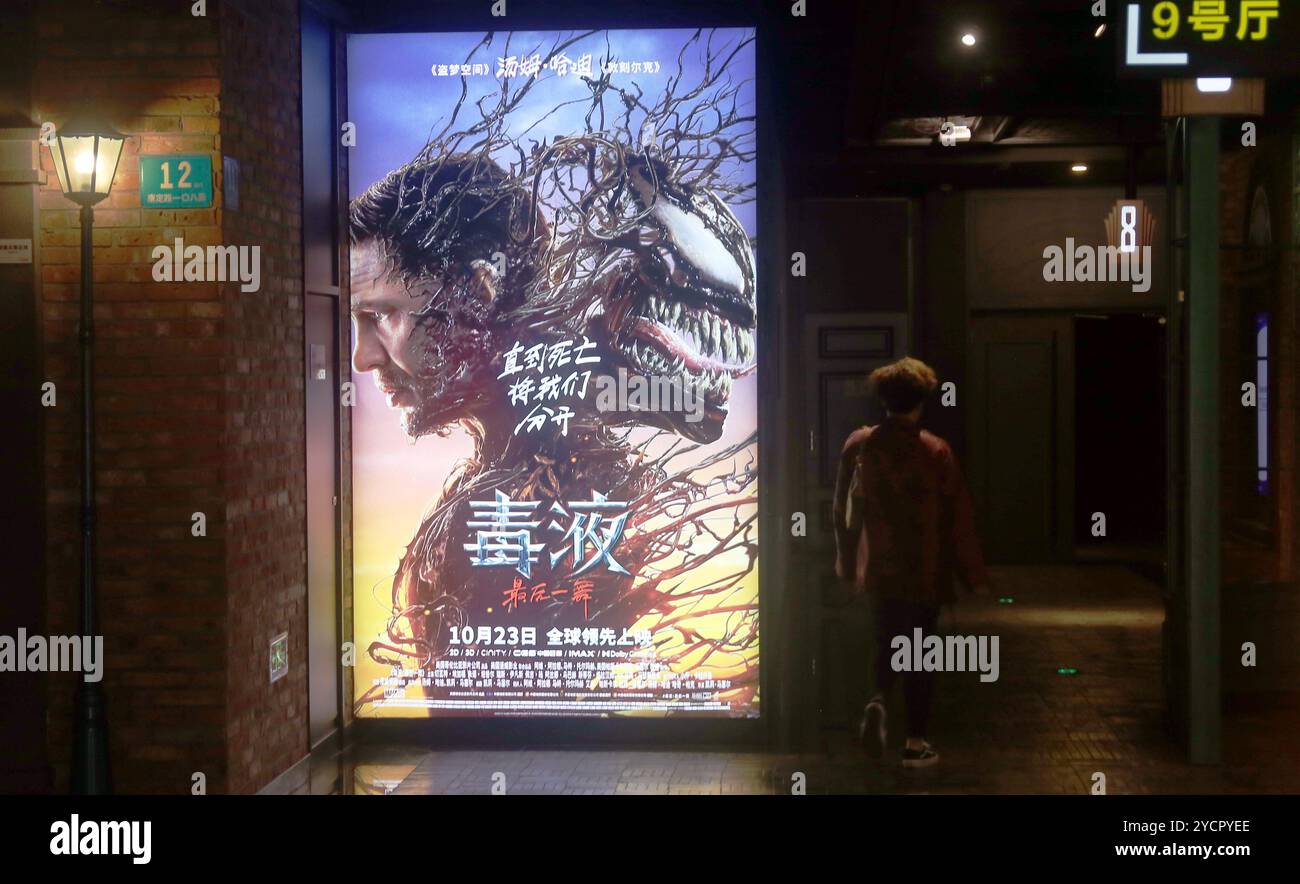 SHANGHAI, CHINA OCTOBER 23, 2024 - A fan passes a poster of The Venom ...