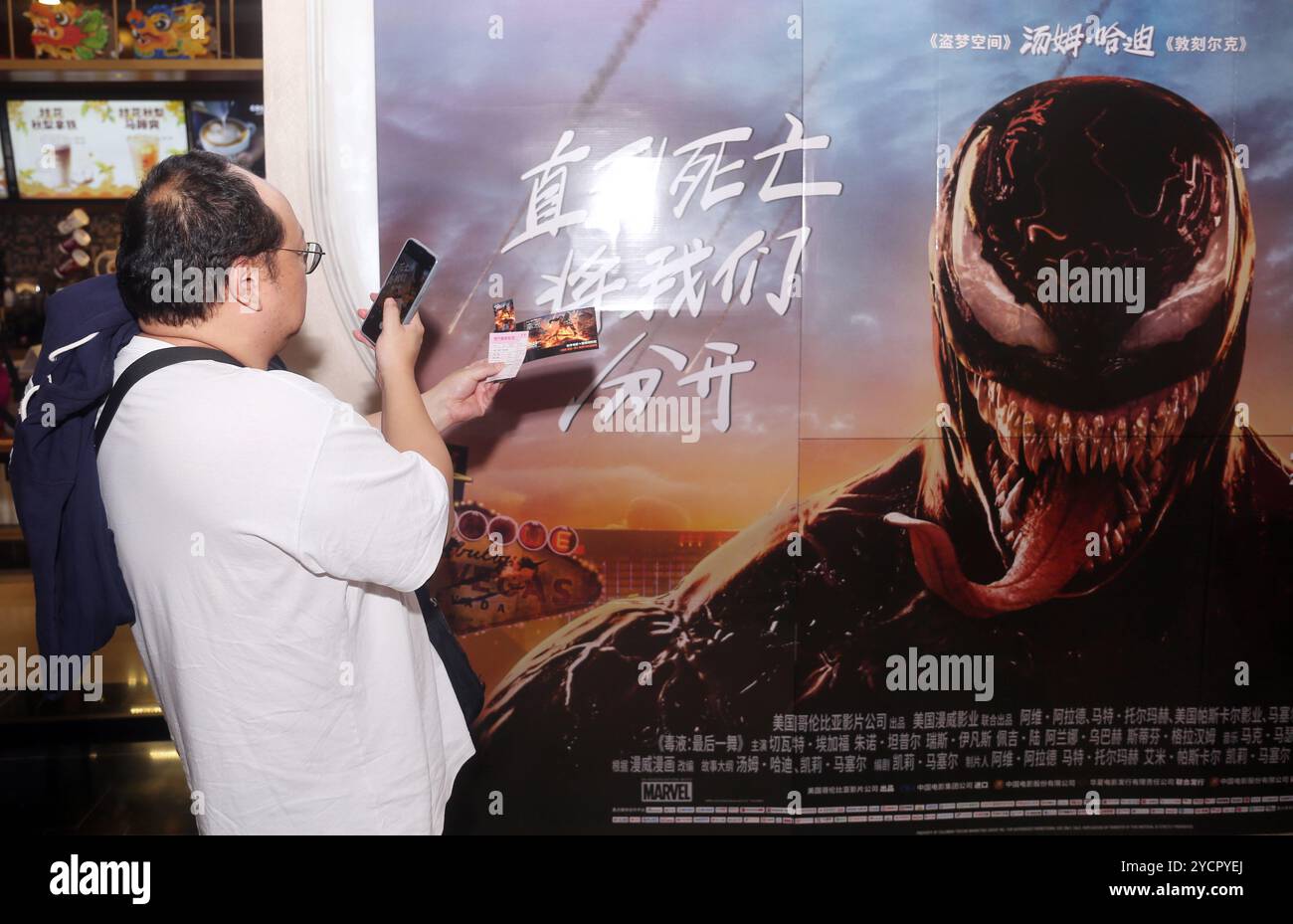 SHANGHAI, CHINA OCTOBER 23, 2024 - A fan poses with a poster of The ...