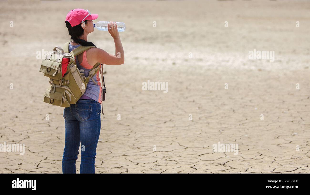 Traveller drinking water from bottle in the desert Stock Photo - Alamy