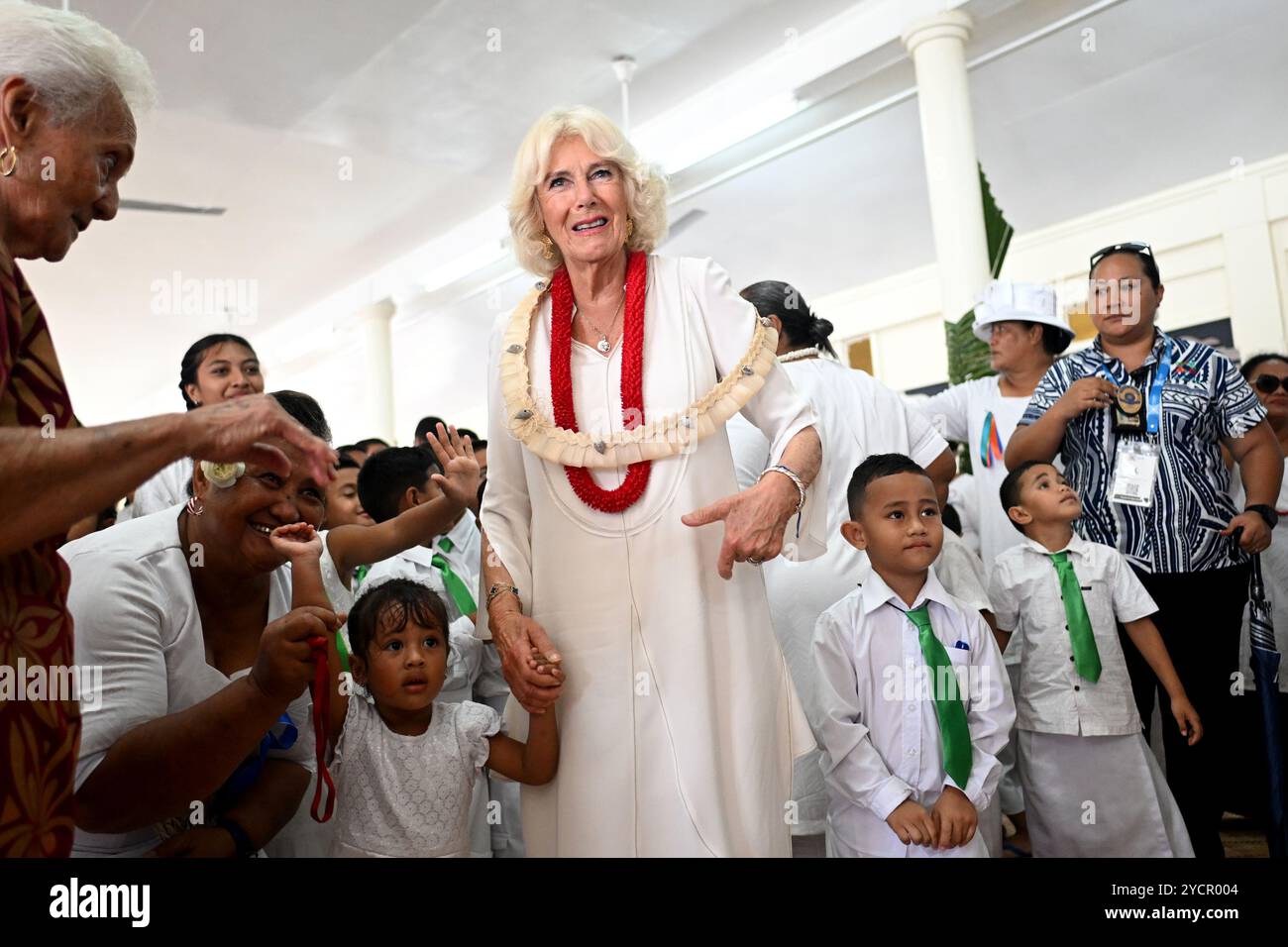 Queen Camilla wears a gift presented to her at Moata'a village's aoga ...