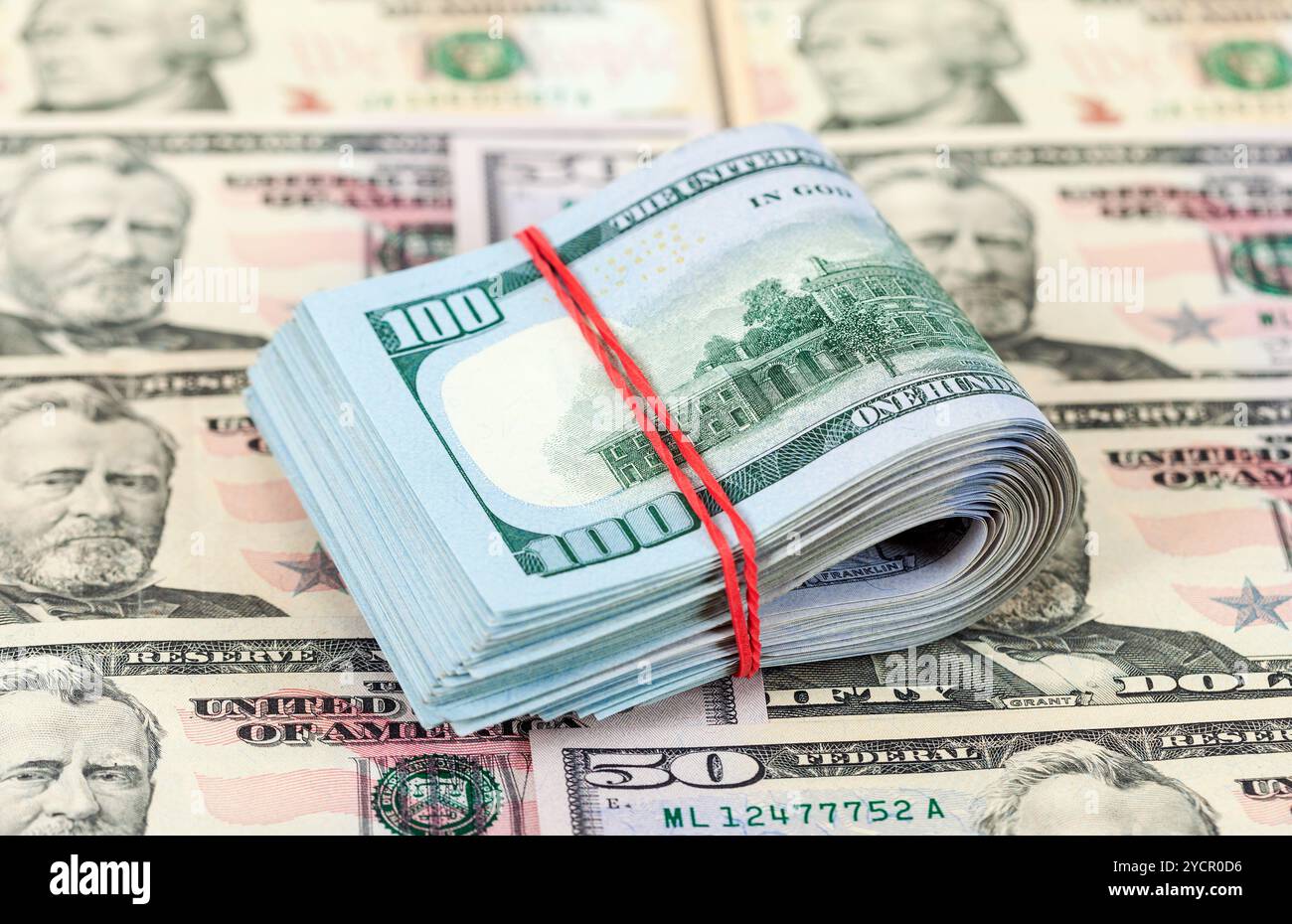 Folded dollar bills wrapped by rubber lying over banknotes Stock Photo ...