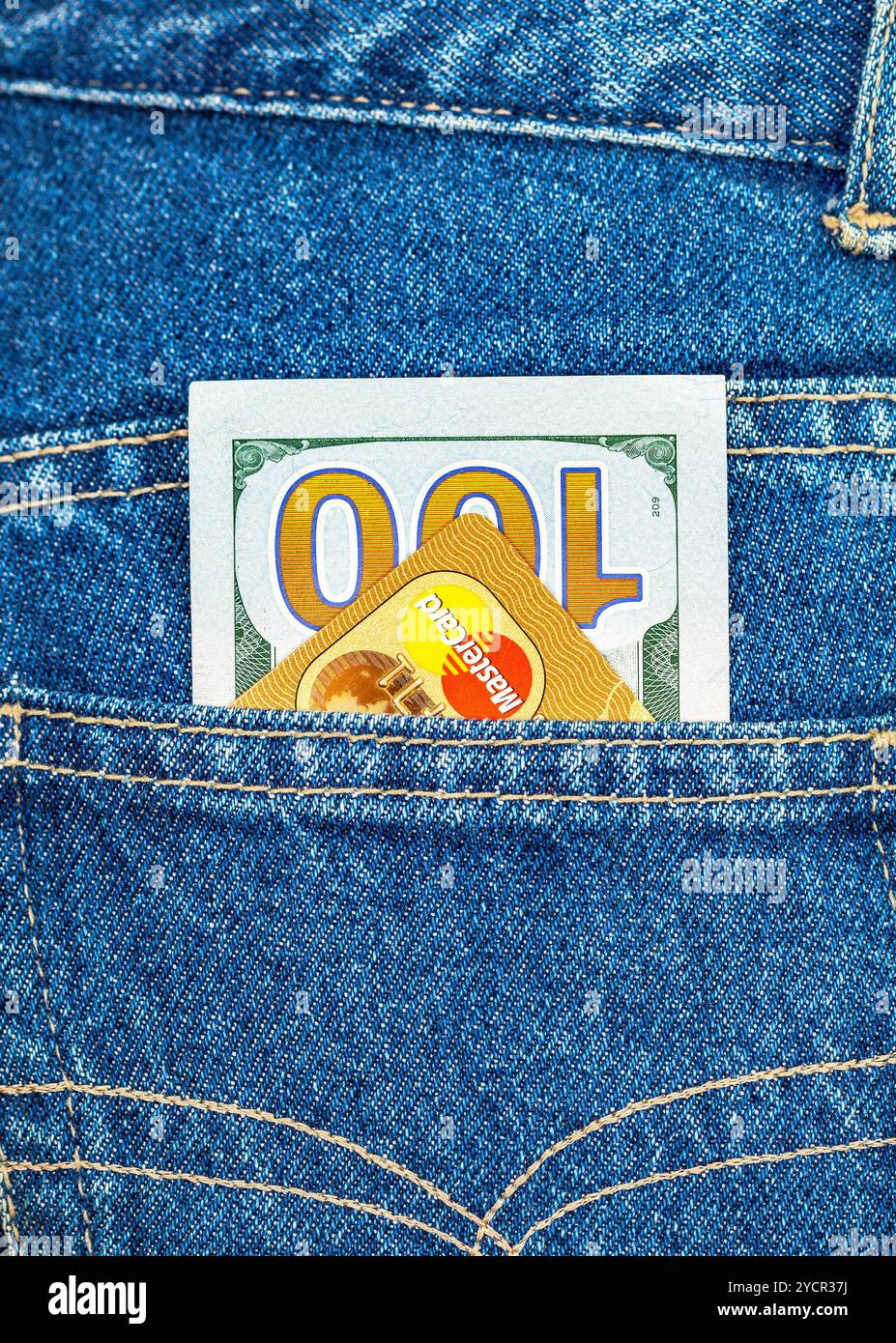 Credit card MasterCard with US dollars sticking out of the back jeans ...